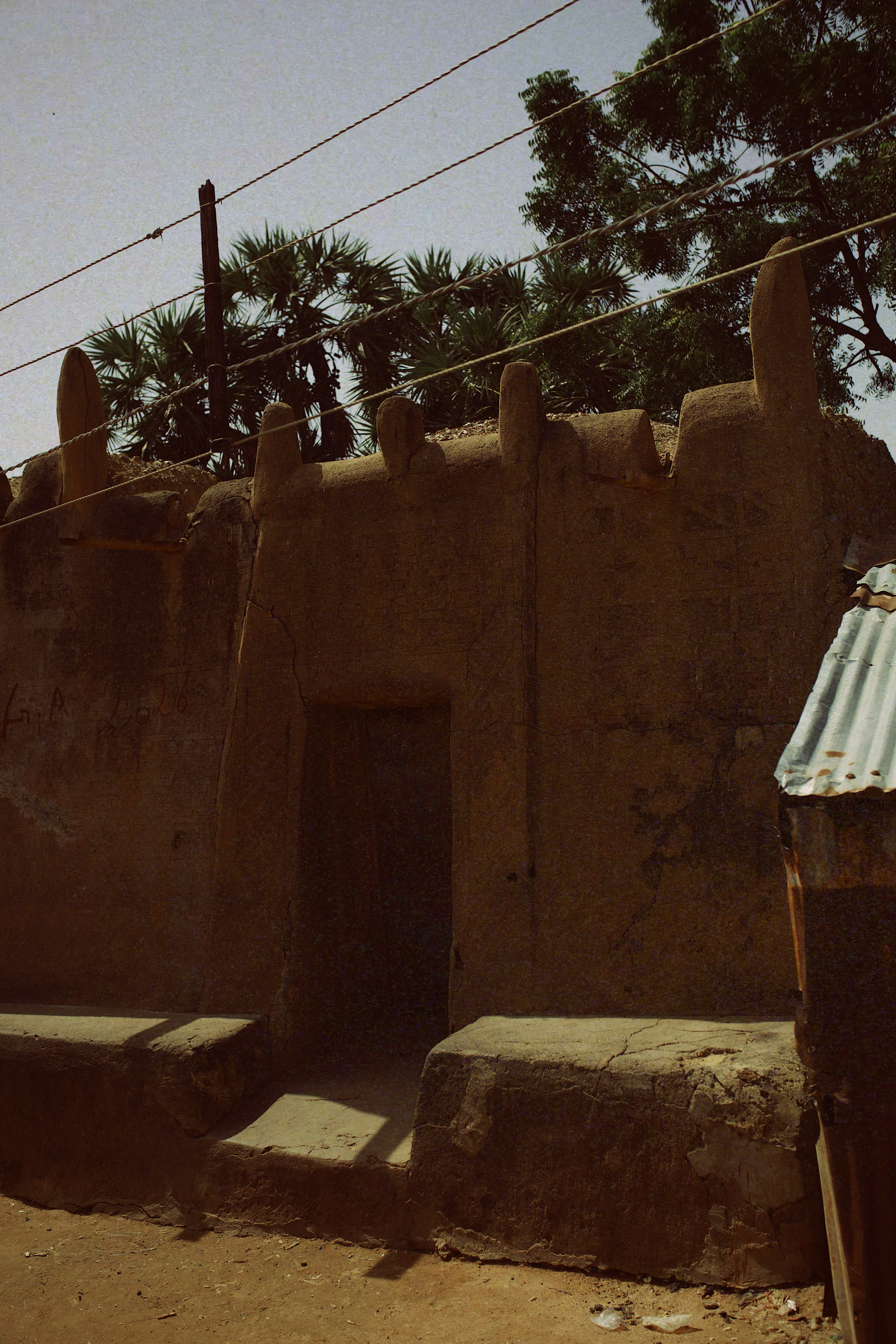 Mud-walled Gatehouse Under Palm Shaded Sky