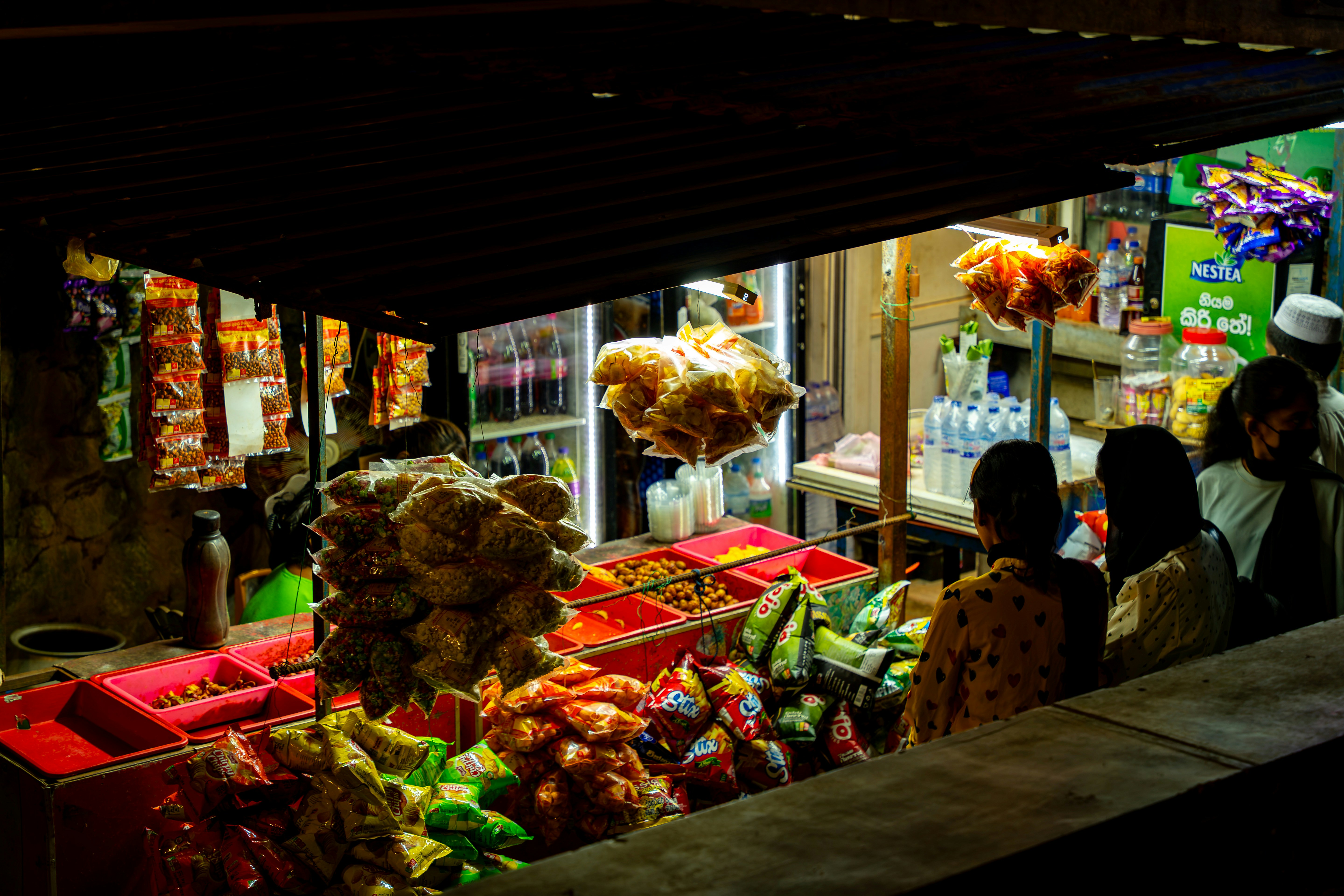 Market Stall Glow: Bags of Snack Treasures under Evening Fluorescents