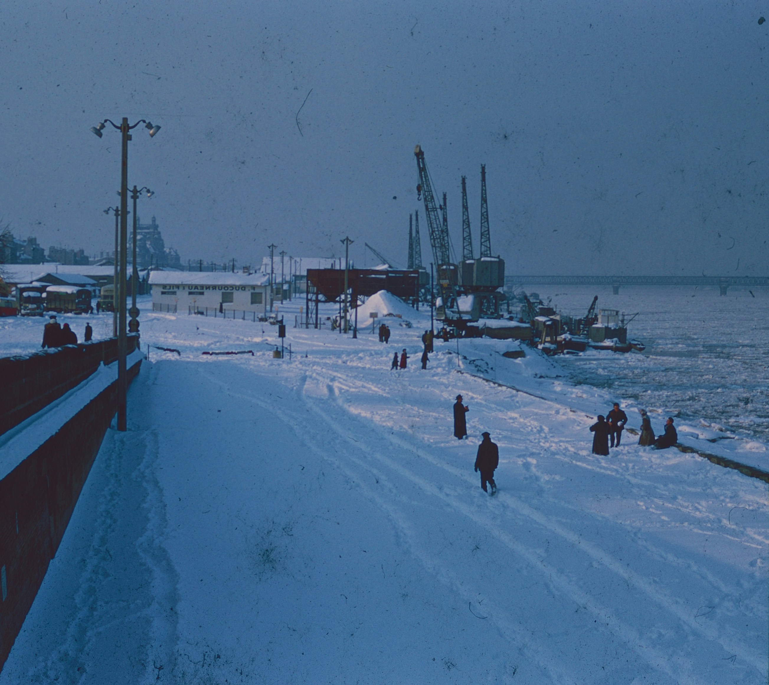 Snowbound Harbor: Crane Silhouettes Along the Frozen Pier