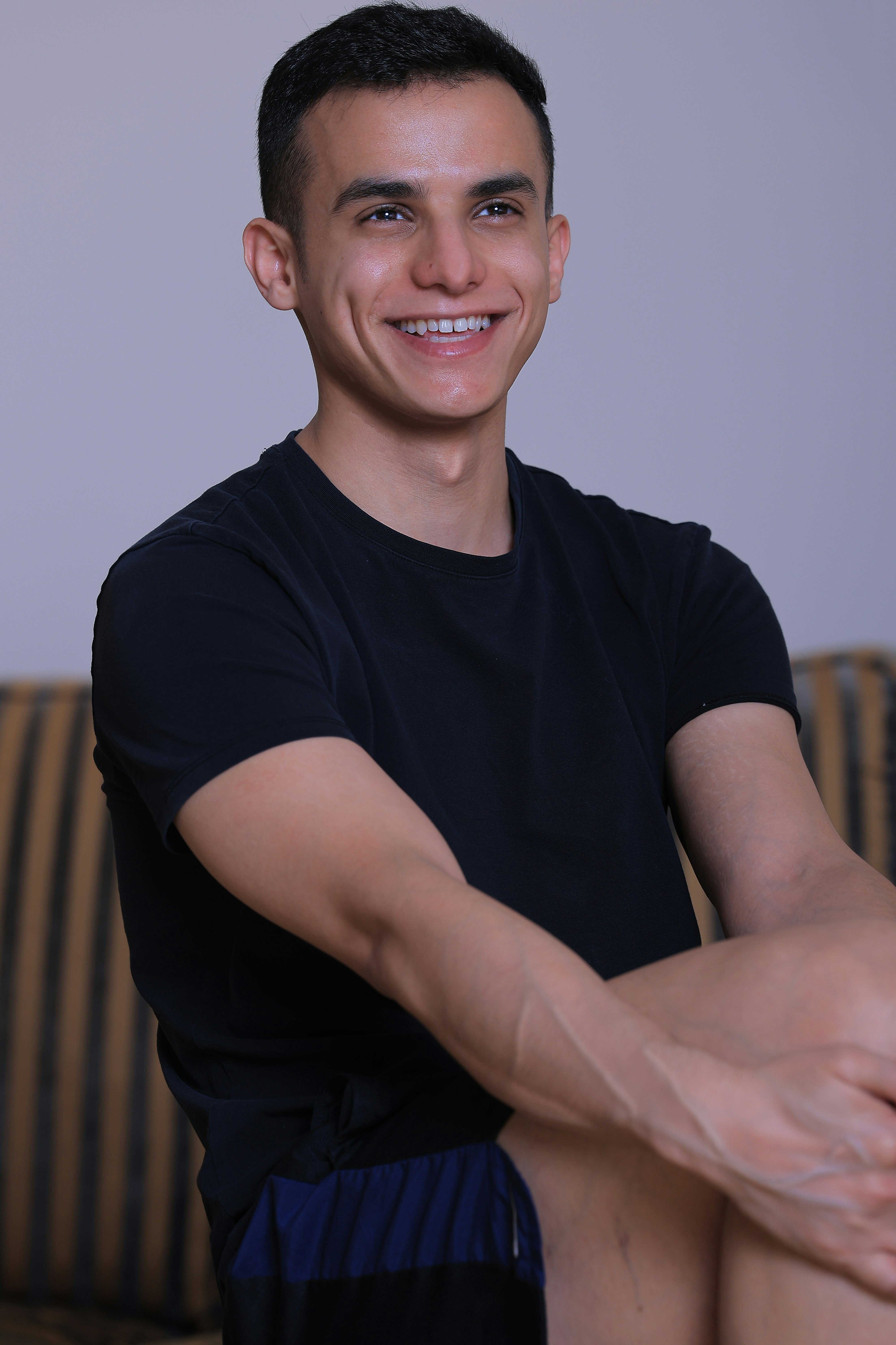 Smiling Confidence: Portrait of a Relaxed Individual on a Neutral Set