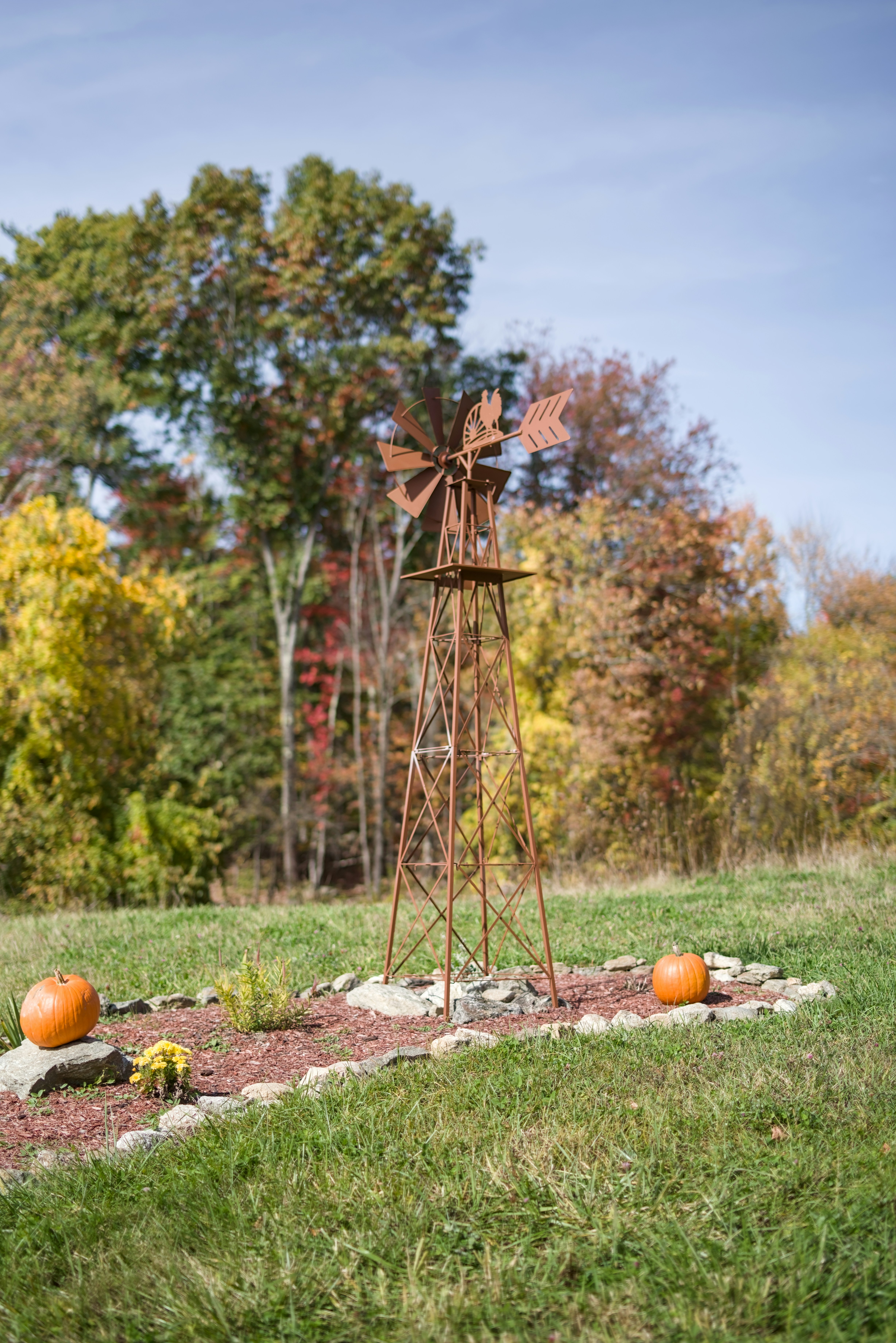 Rusted windmill guardian amid autumn garden