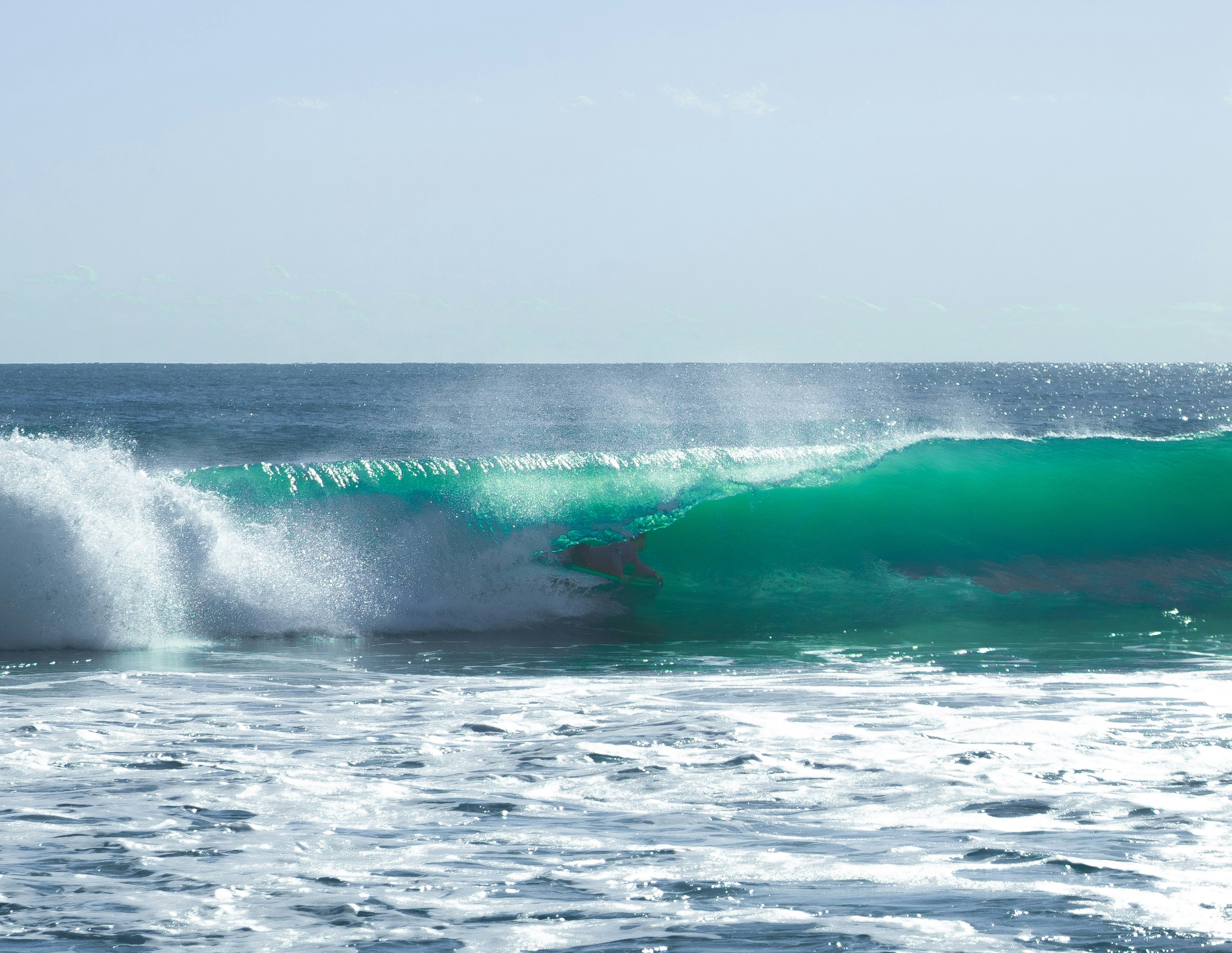 Mid‑Wave Rider: A turquoise barrel hides a surfer beneath
