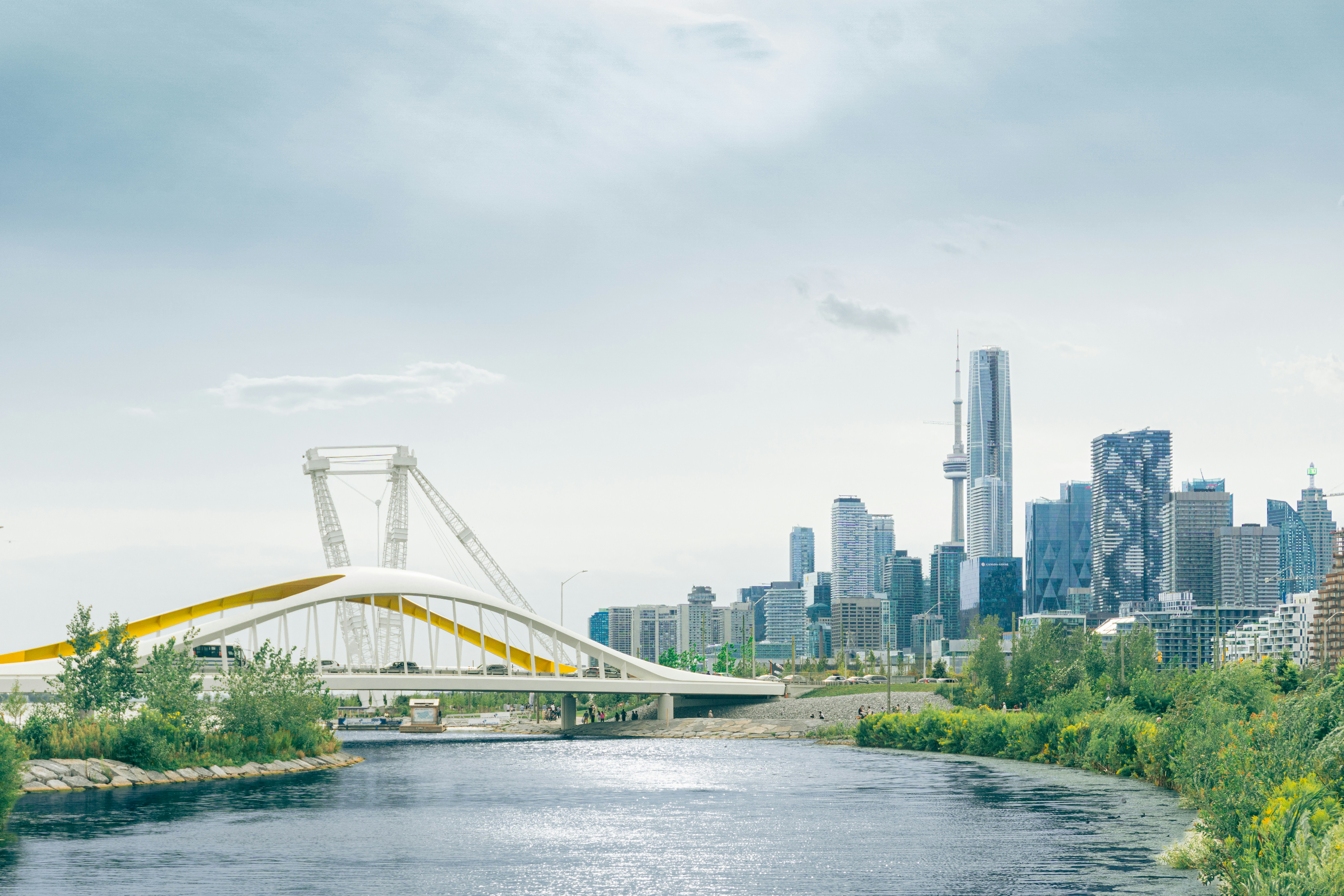 Acurved Yellow Arch over a River Framing a Modern Skyline
