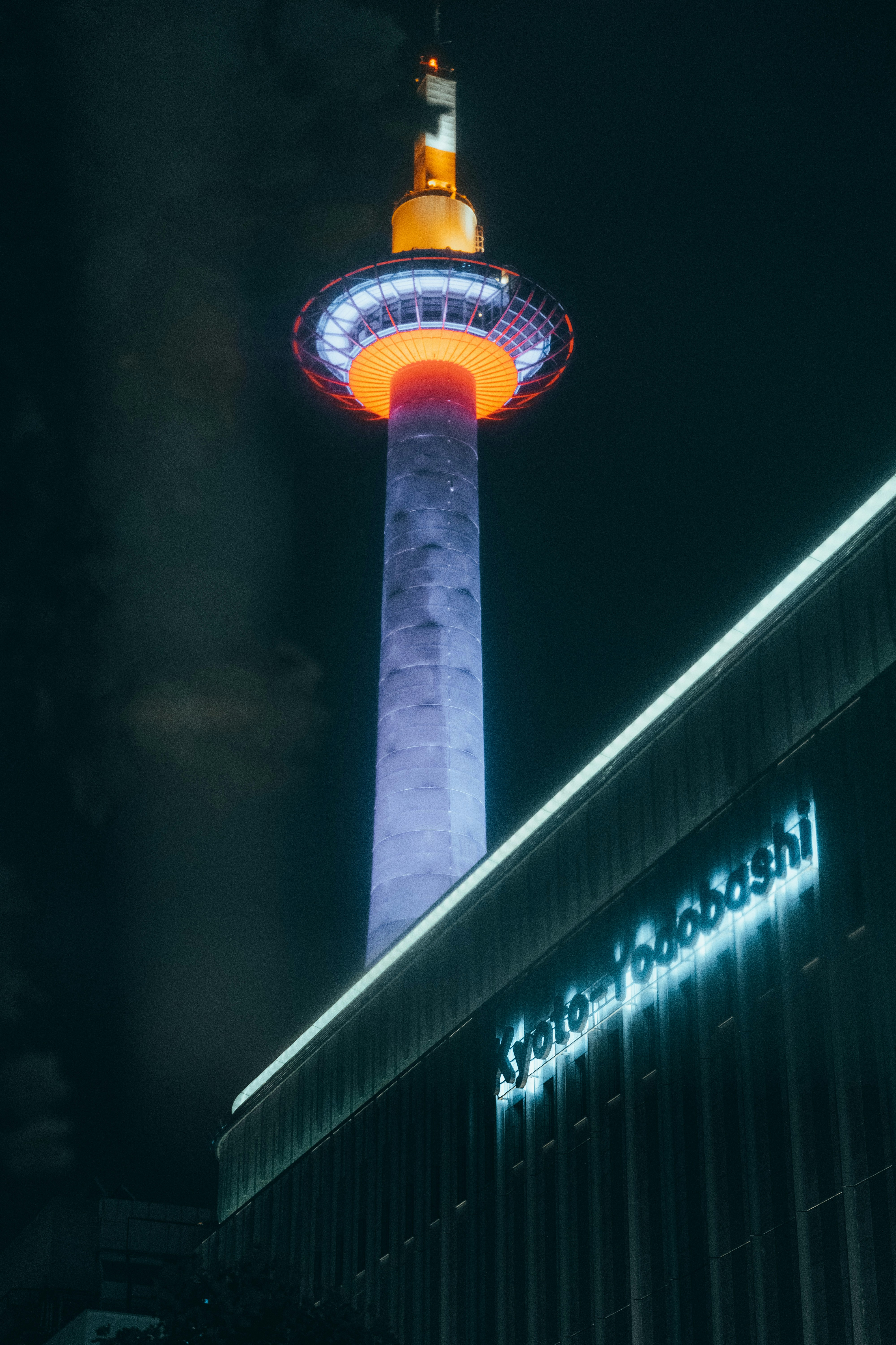 Neon Torch: Night Colossus Rising Over a Modern Facade