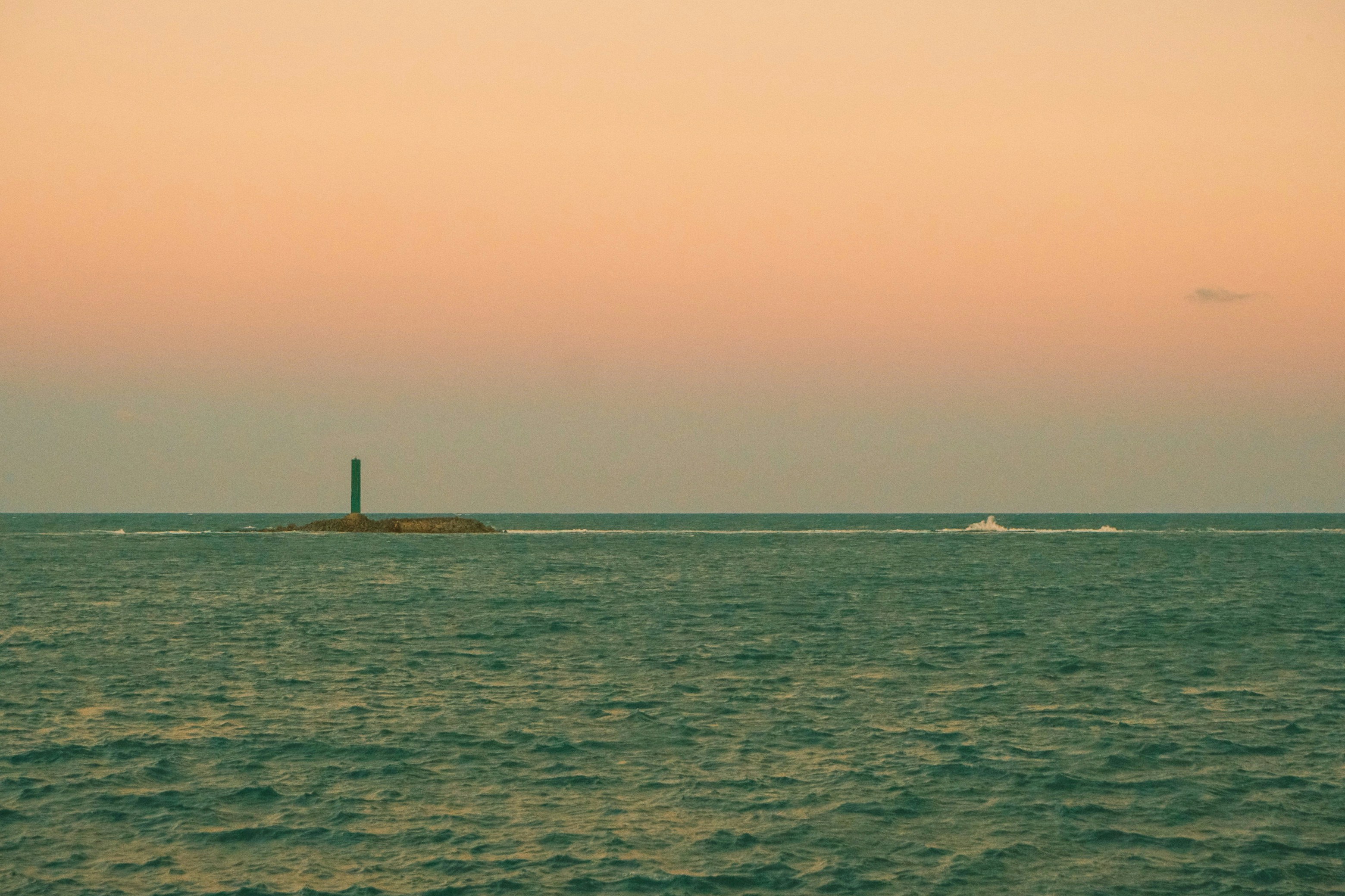 Horizon Break: A Quiet Lighthouse Beneath a Peach Sky