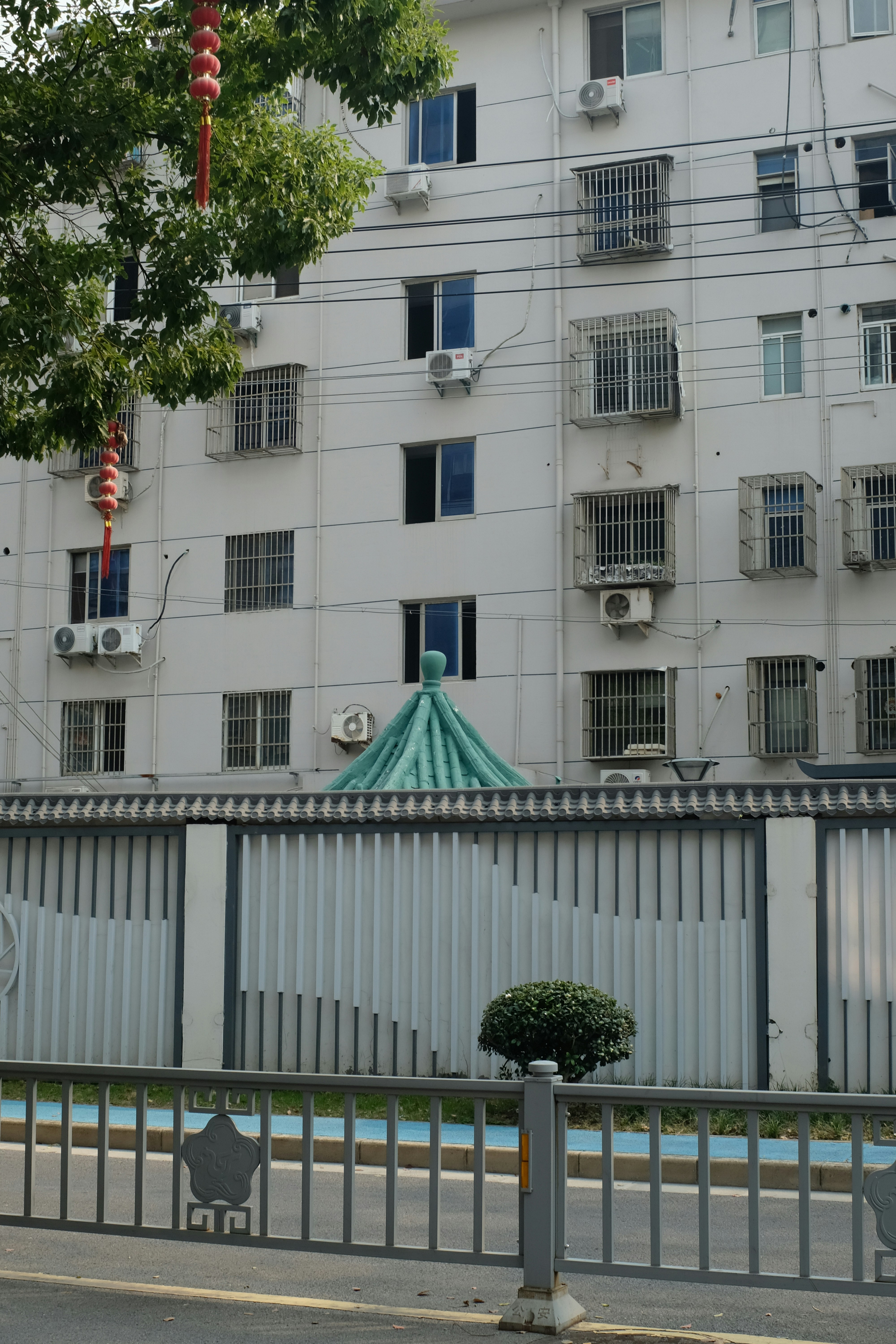 Green-roofed pavilion against a tower of urban windows