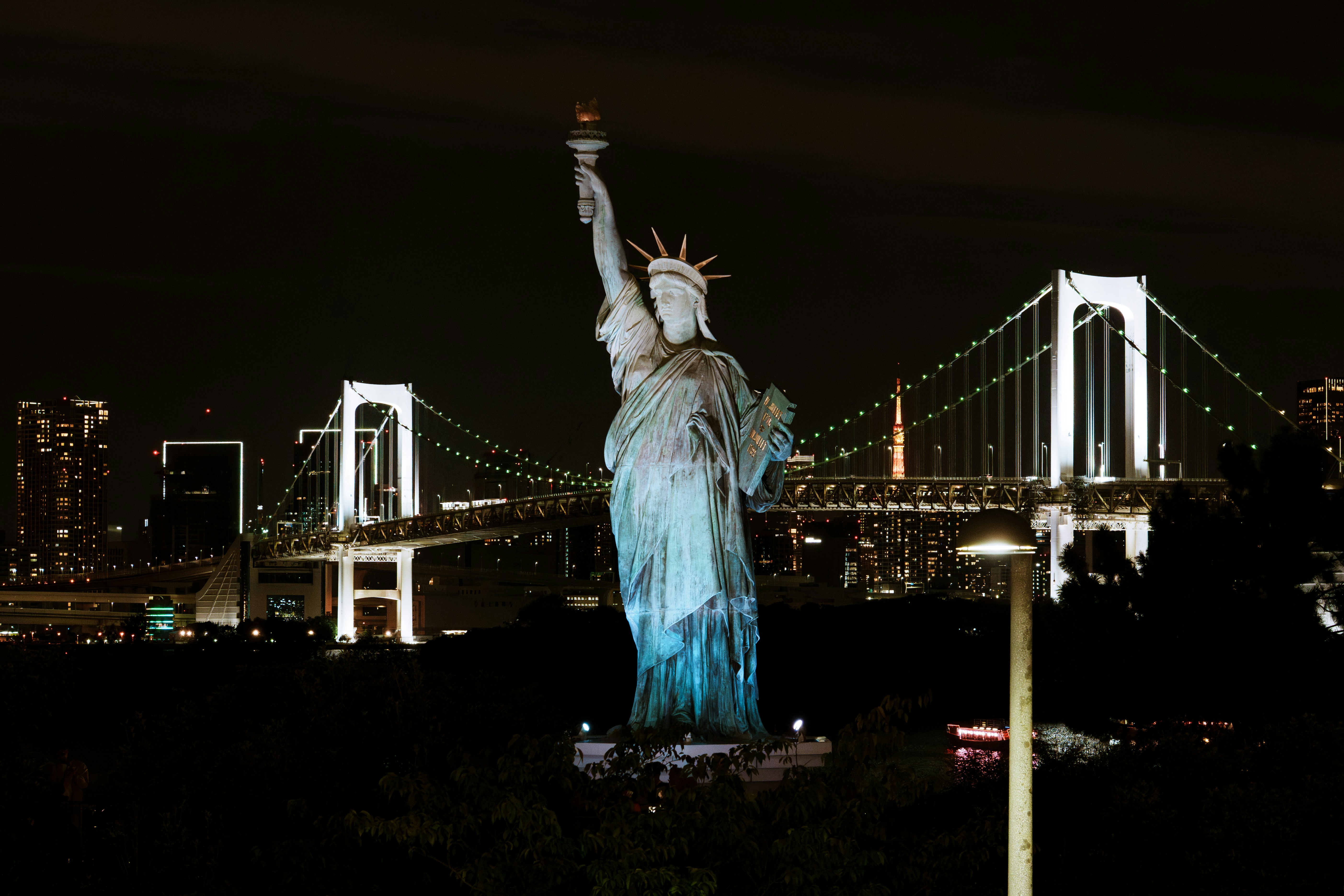 Statue of Liberty Silhouette Over Tokyo-Style Night Bridge