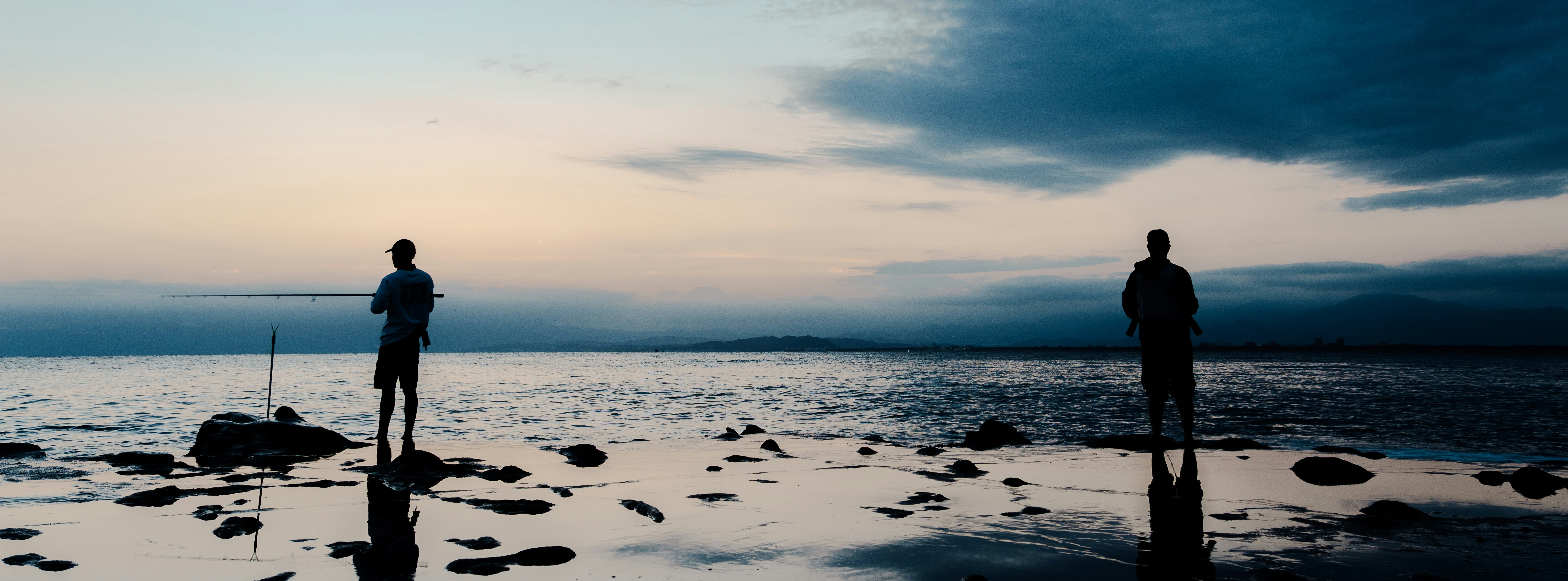 Twin Silhouettes at Dusk: Casting Lines Across the Quiet Tide