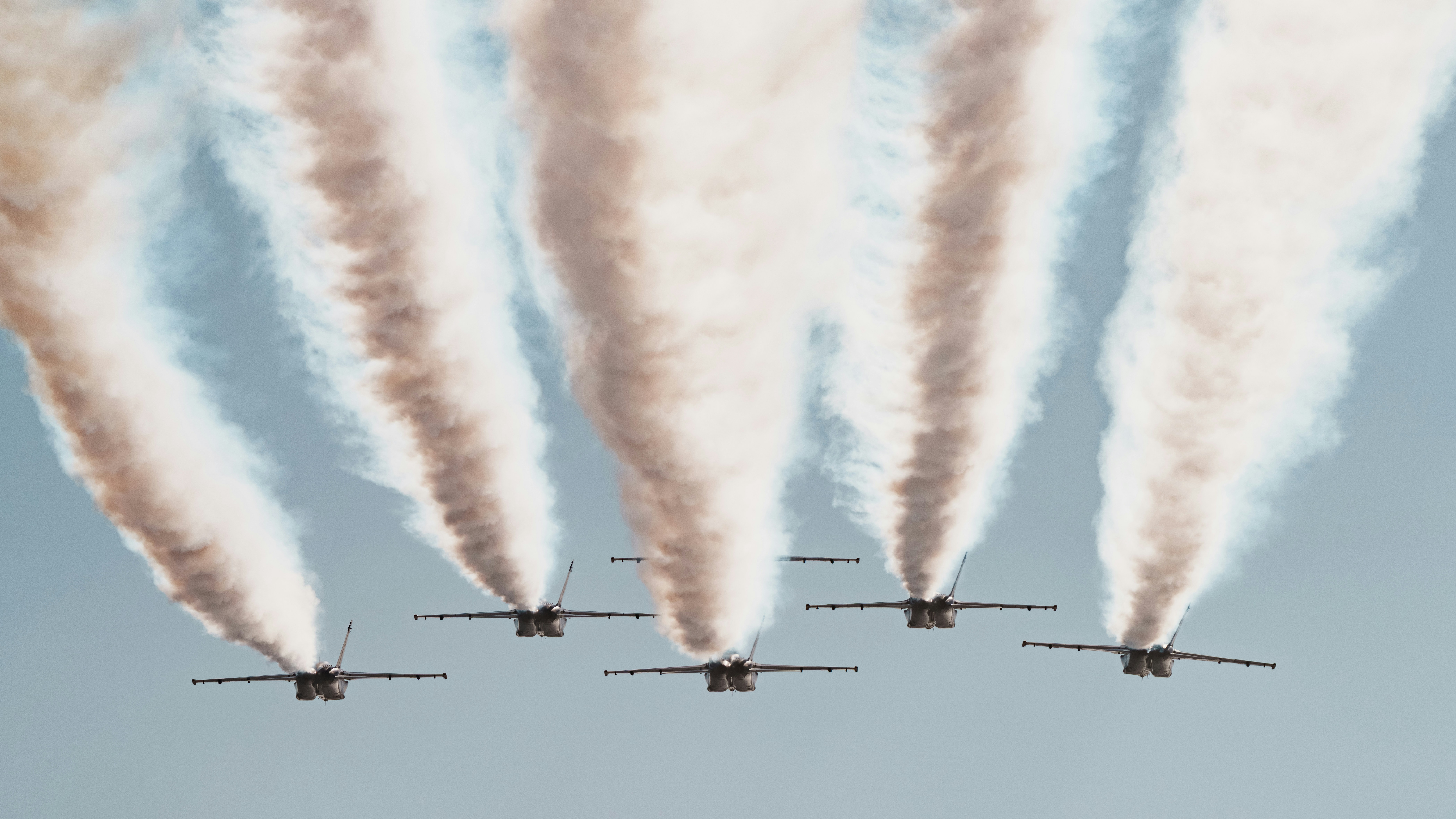 Contrails in Formation: Five Wings Cutting Through a Clear Sky