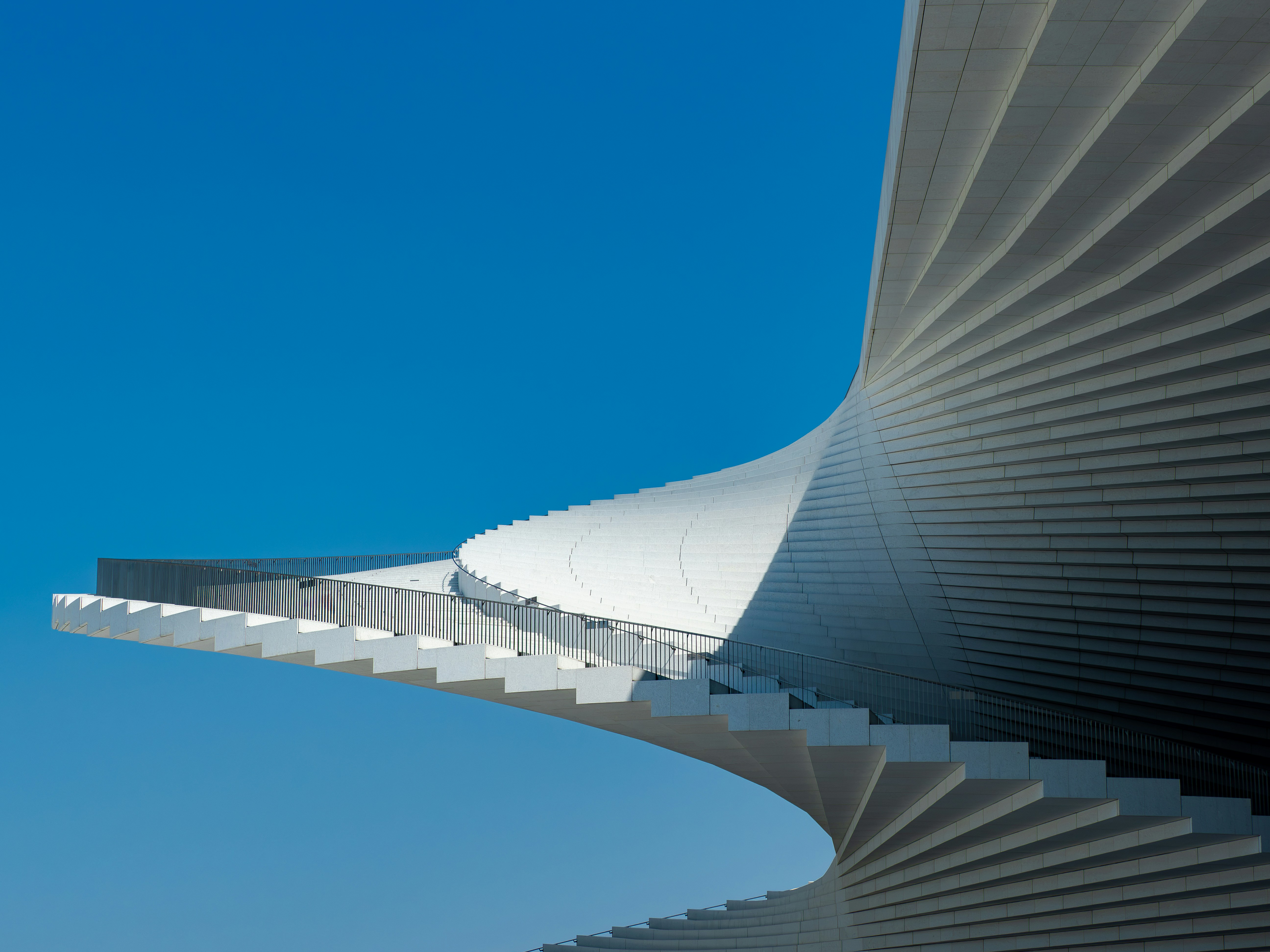 Flowing Metal Wings Against a Clear Blue Sky