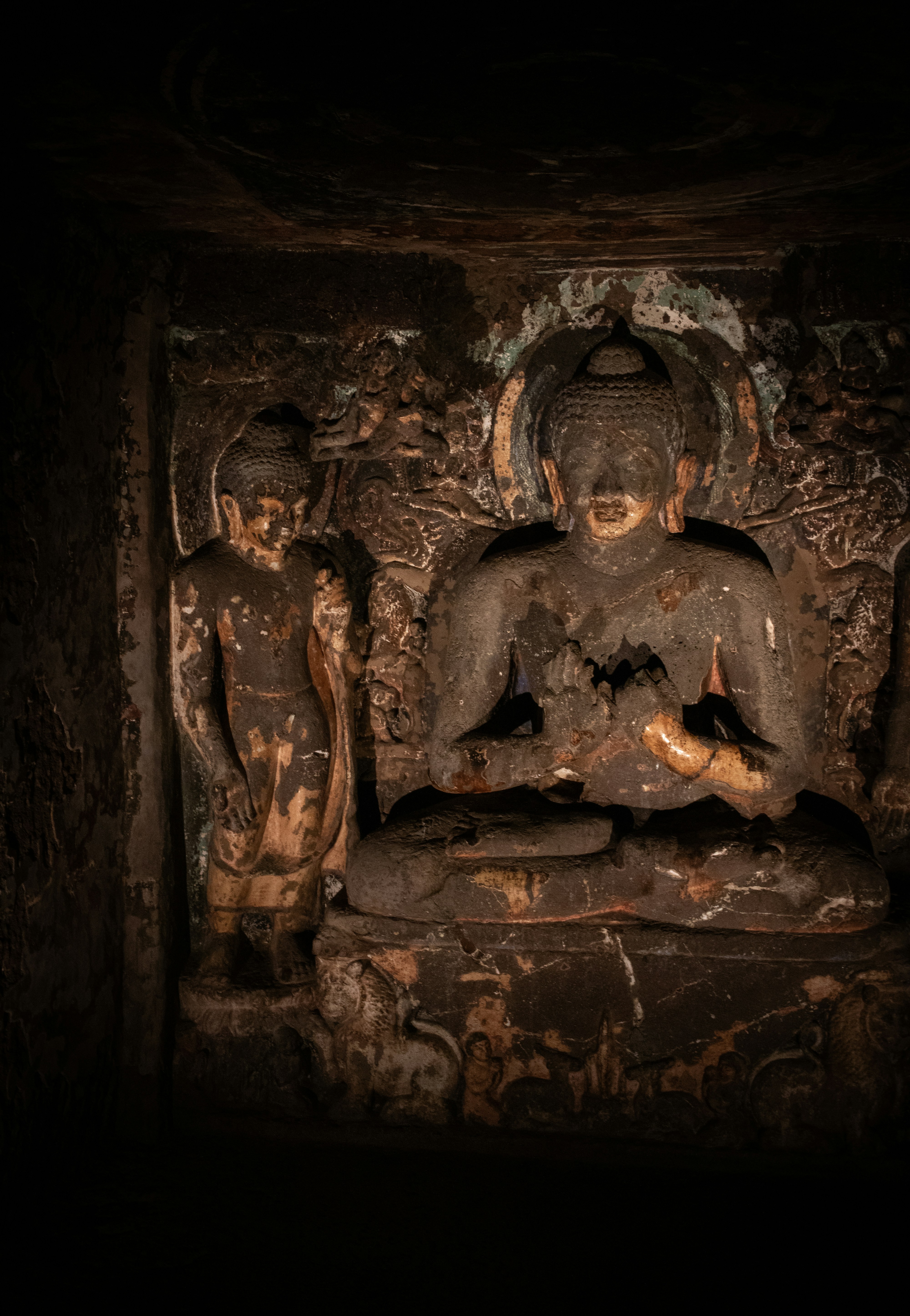 Dim Sanctuary: A Weathered Buddha Emerges from the Wall