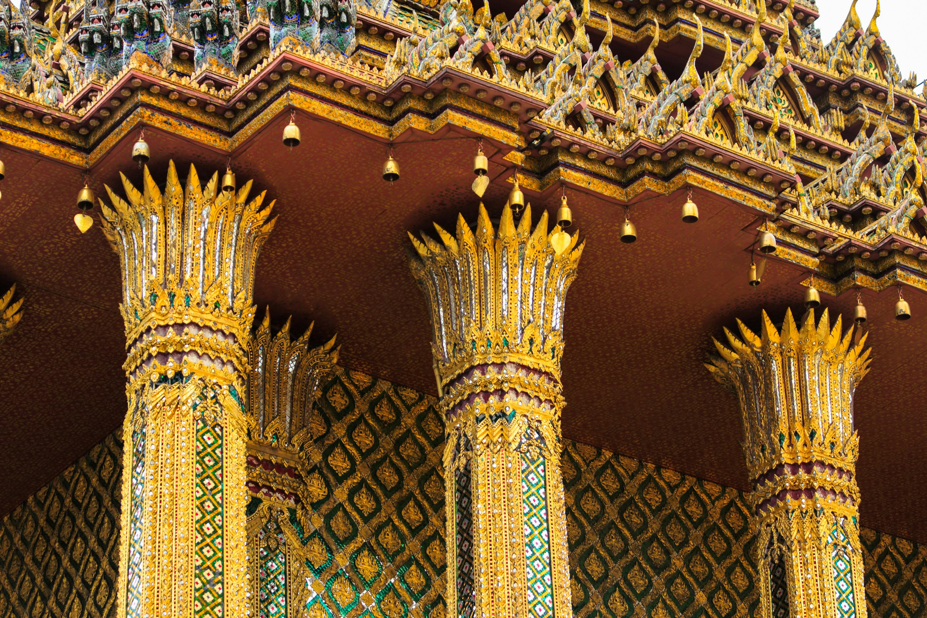 Gilded Carvings and Tiled Columns of a Thai Temple