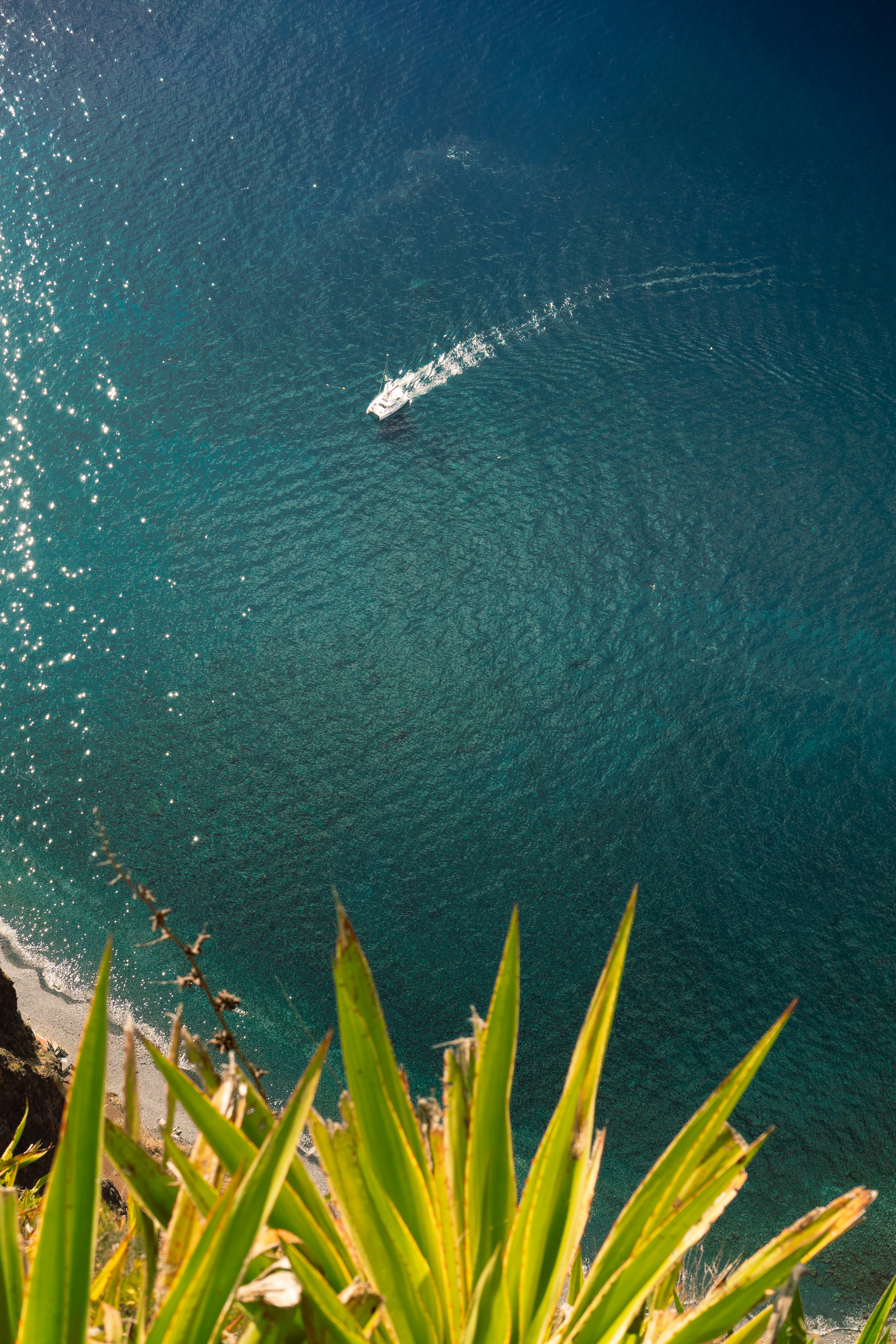 Cliffside Vista: A Boat Carves a Silver Wake in Turquoise Seas