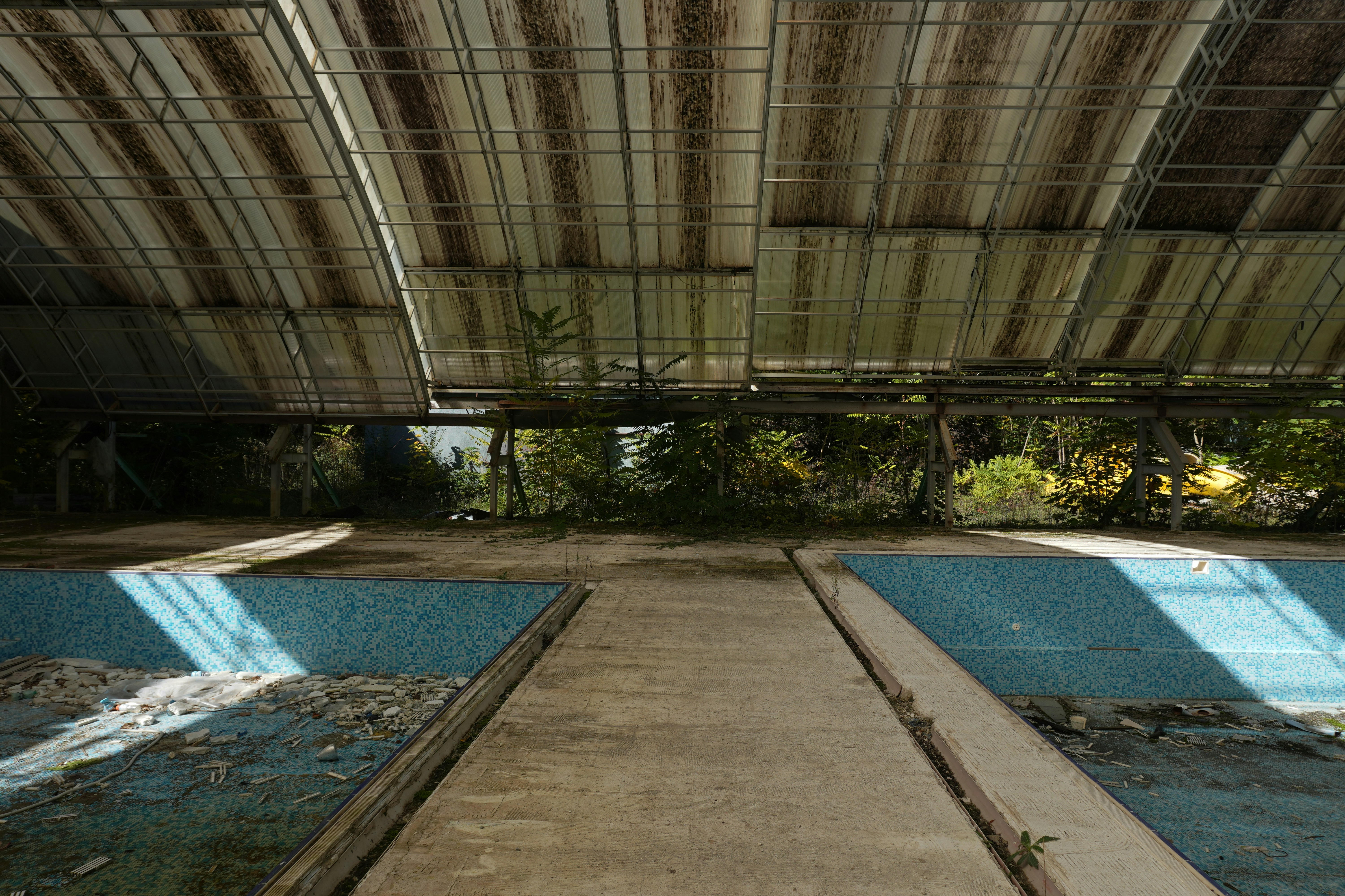 Deserted Pool Corridor under Aged Glass Roof