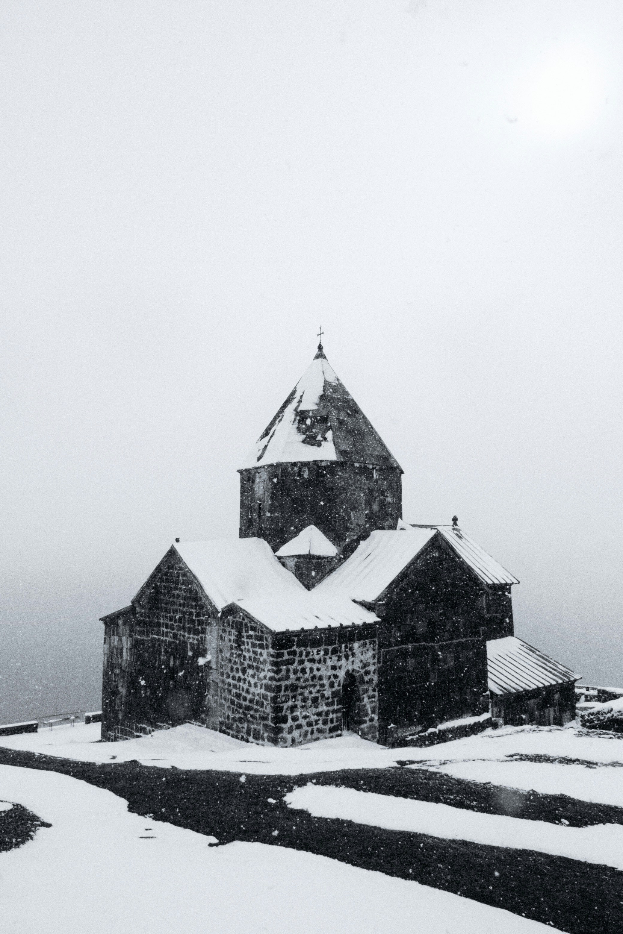 Snowbound Stone Church Against A Pale Sky