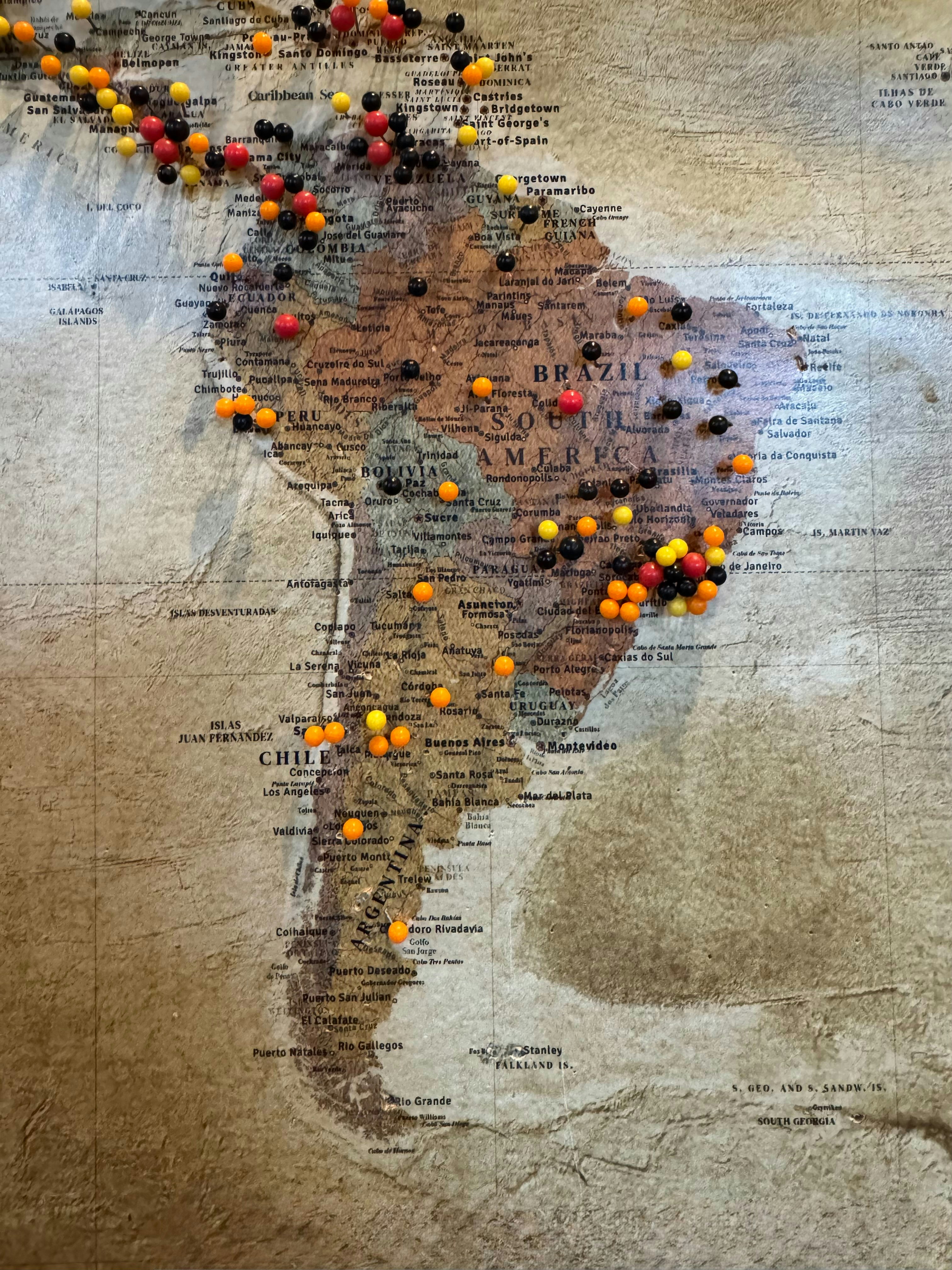 Pins on the Americas: A Vintage World Map Annotated with Colorful Markers