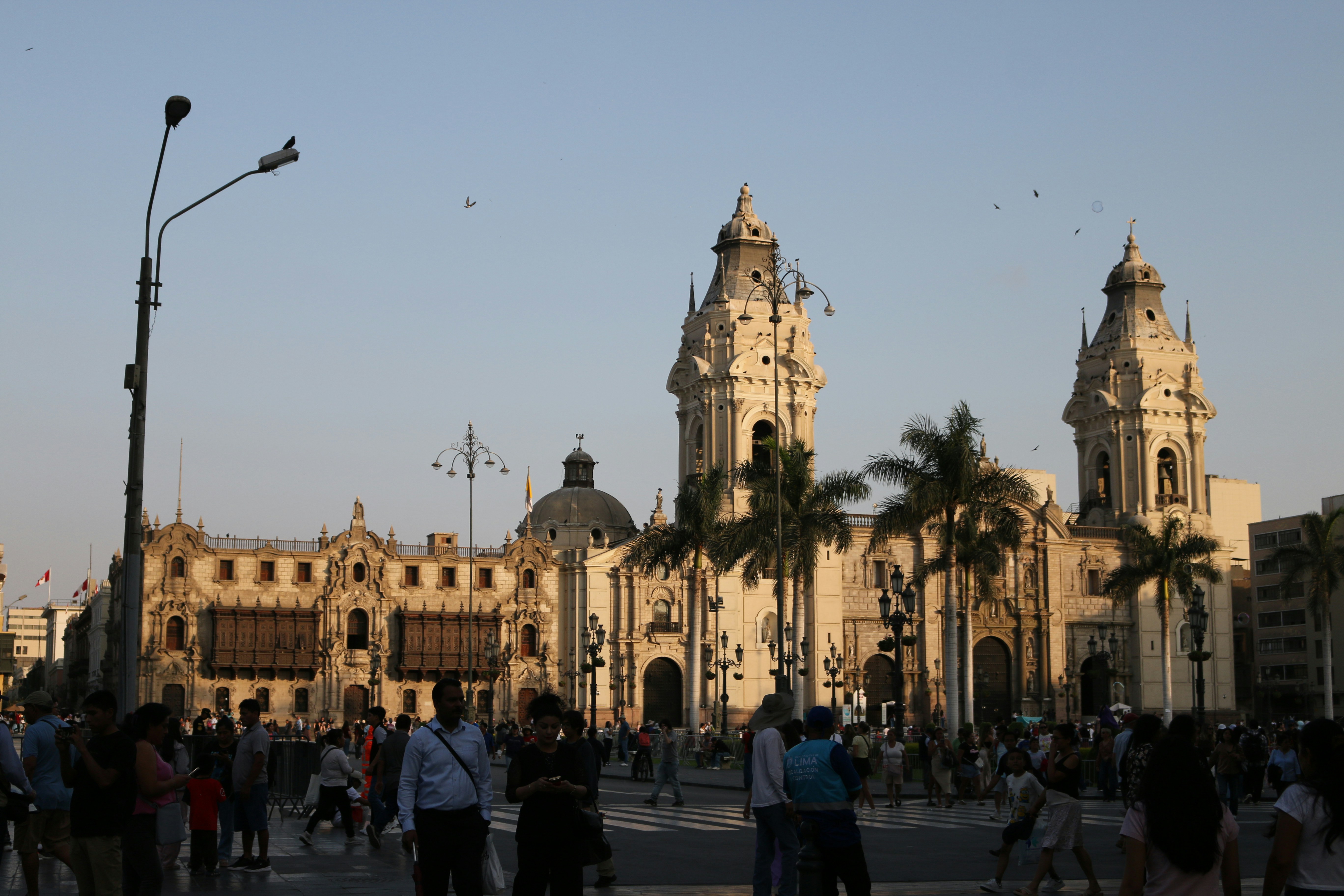 Grand Plaza at Dusk: Colonial Facades and Palm-Lined Courtyard