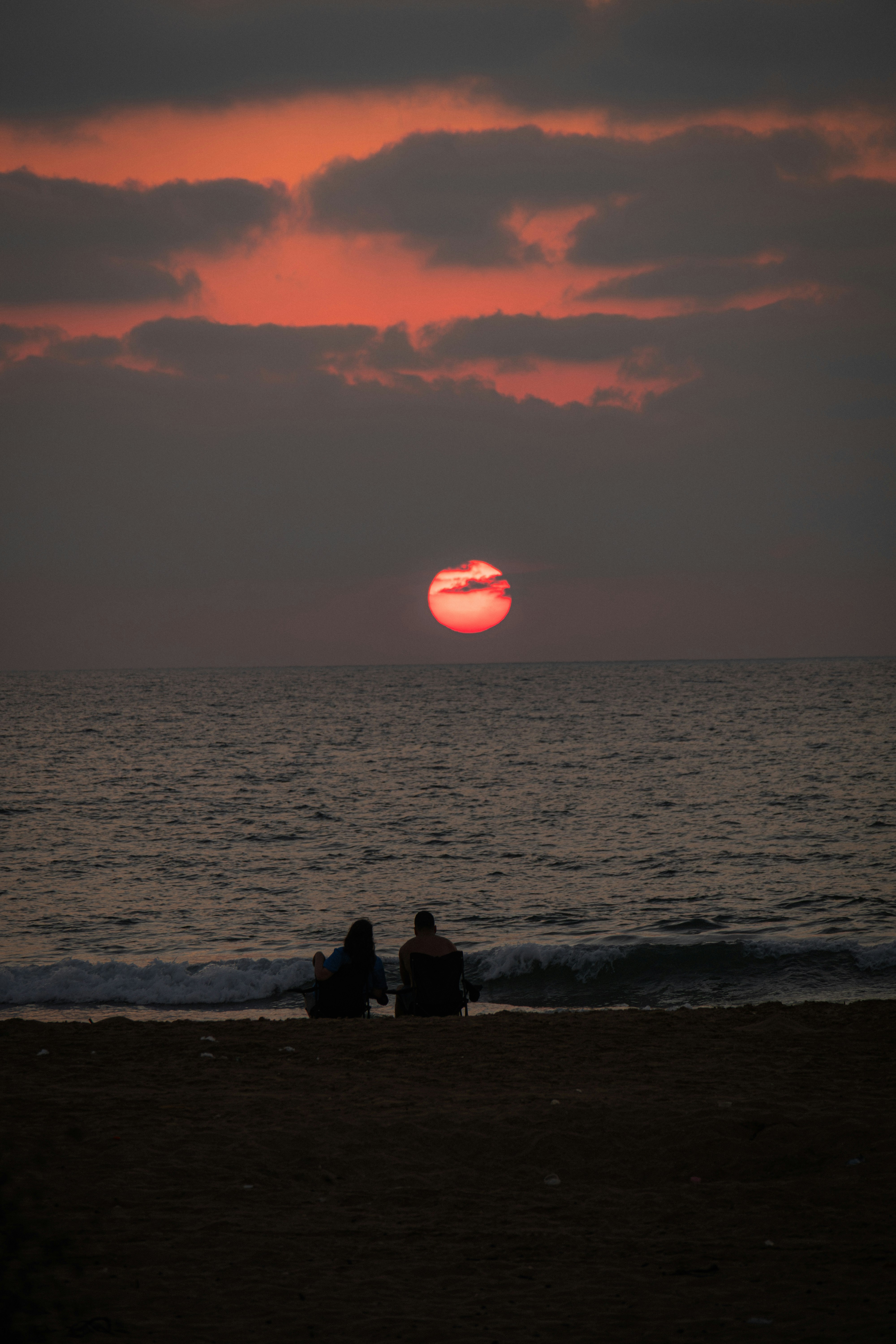 Sunset Embrace: silhouetted lovers on a quiet shore