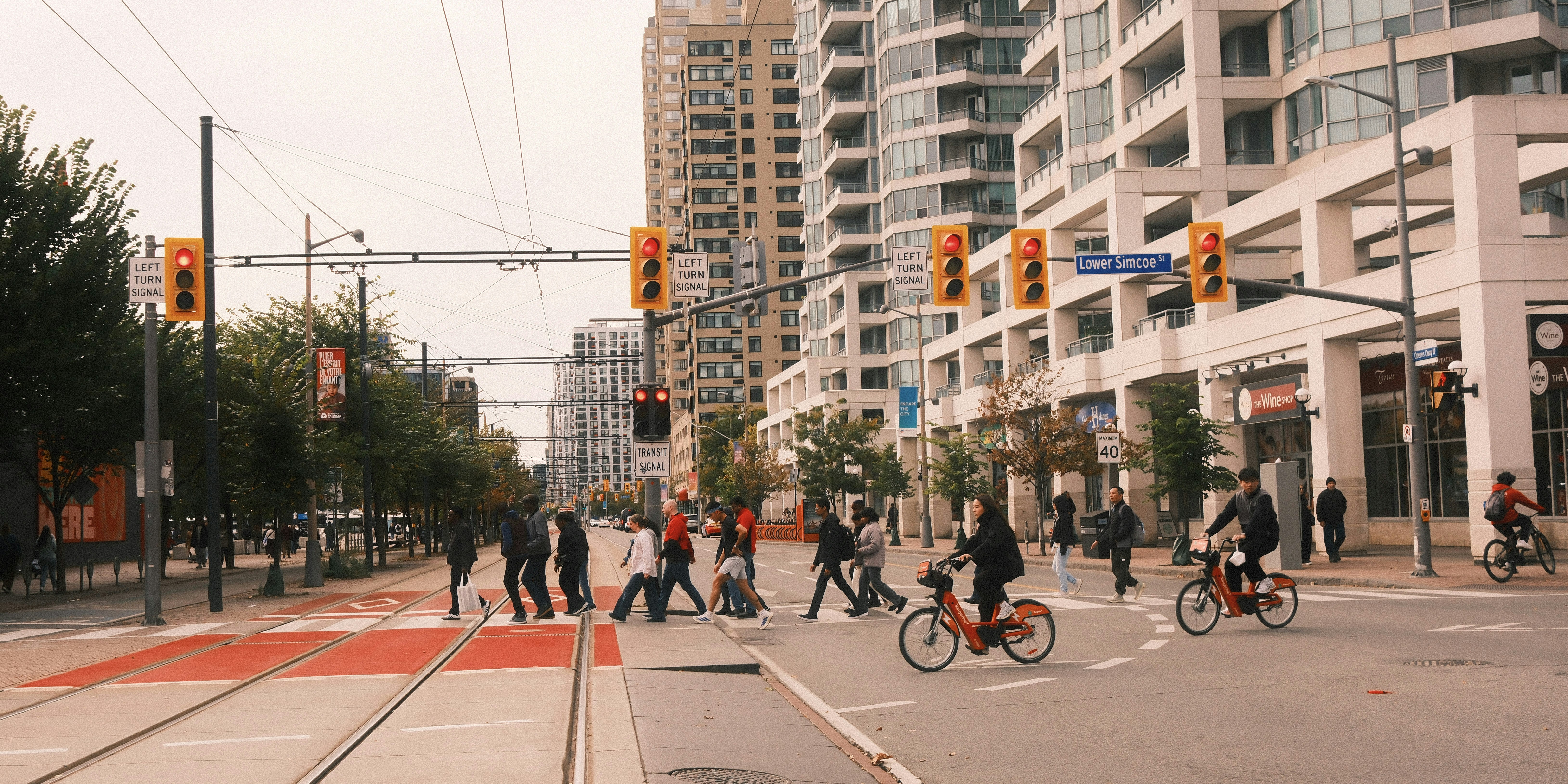 Urban Crossing: Pedestrians and Cyclists Converge at the Red-Tinted Street