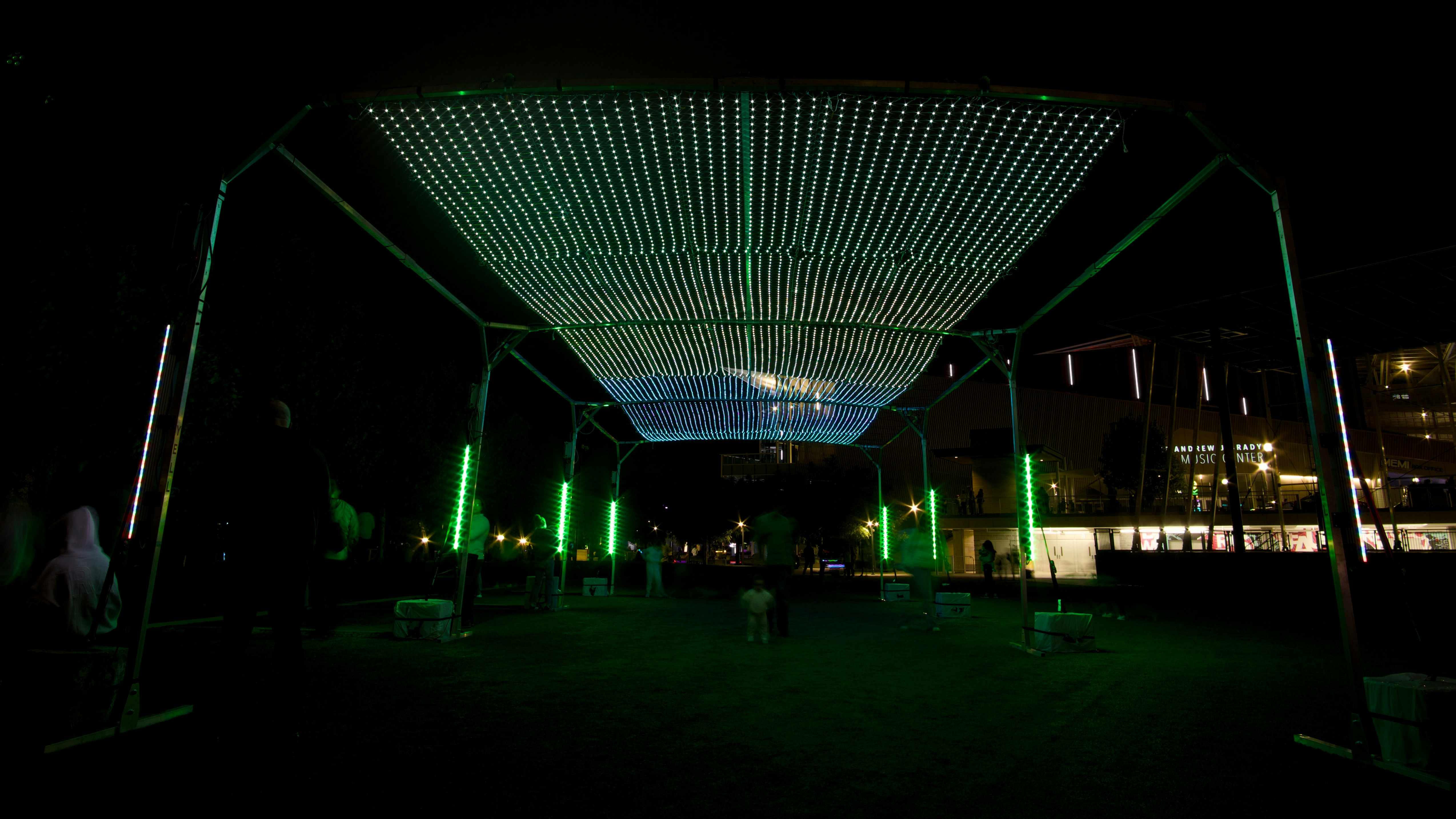 Green-lit canopy corridor at night