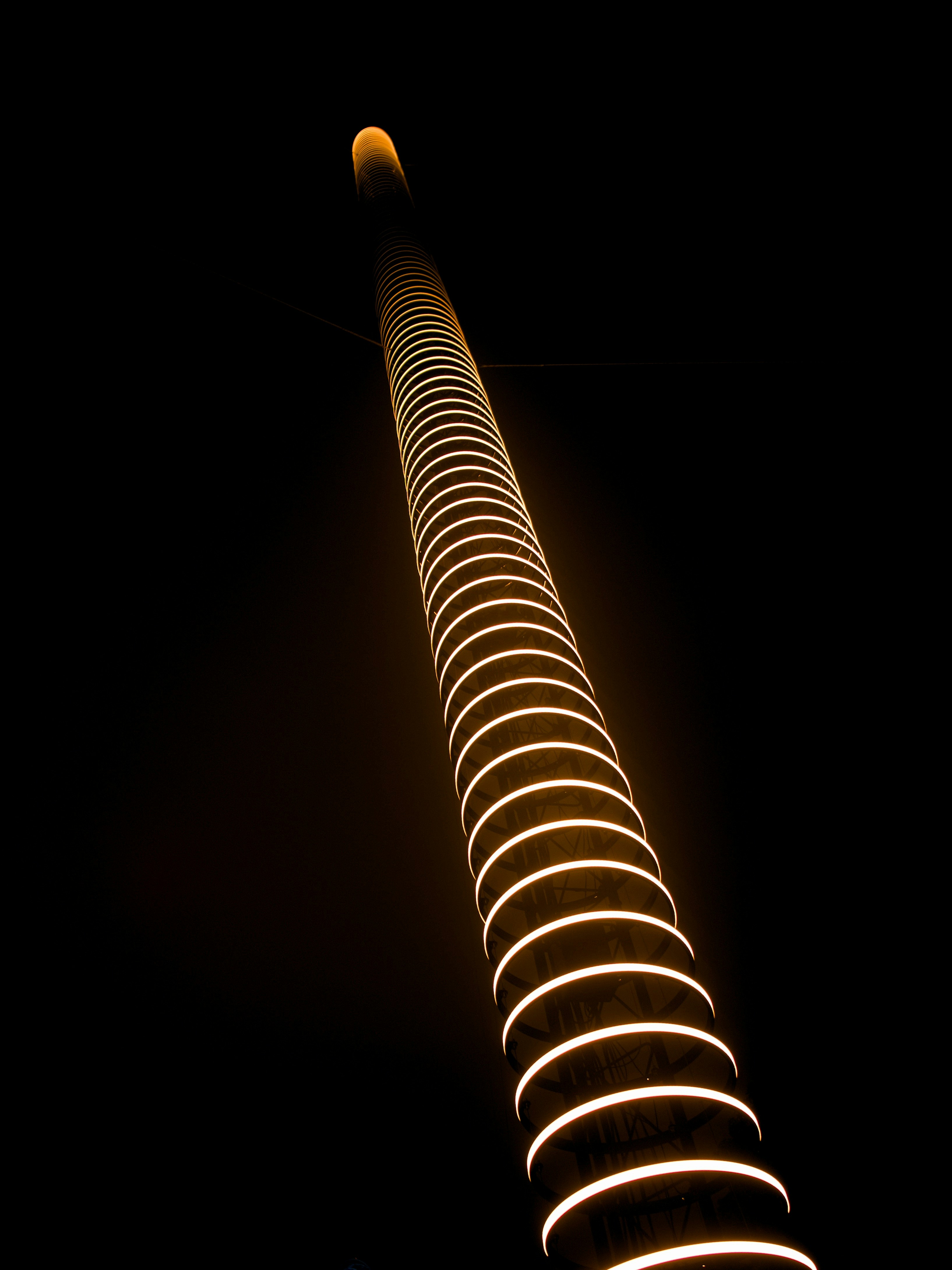 Spiral Light: A Neon Coil Reaching into Darkness