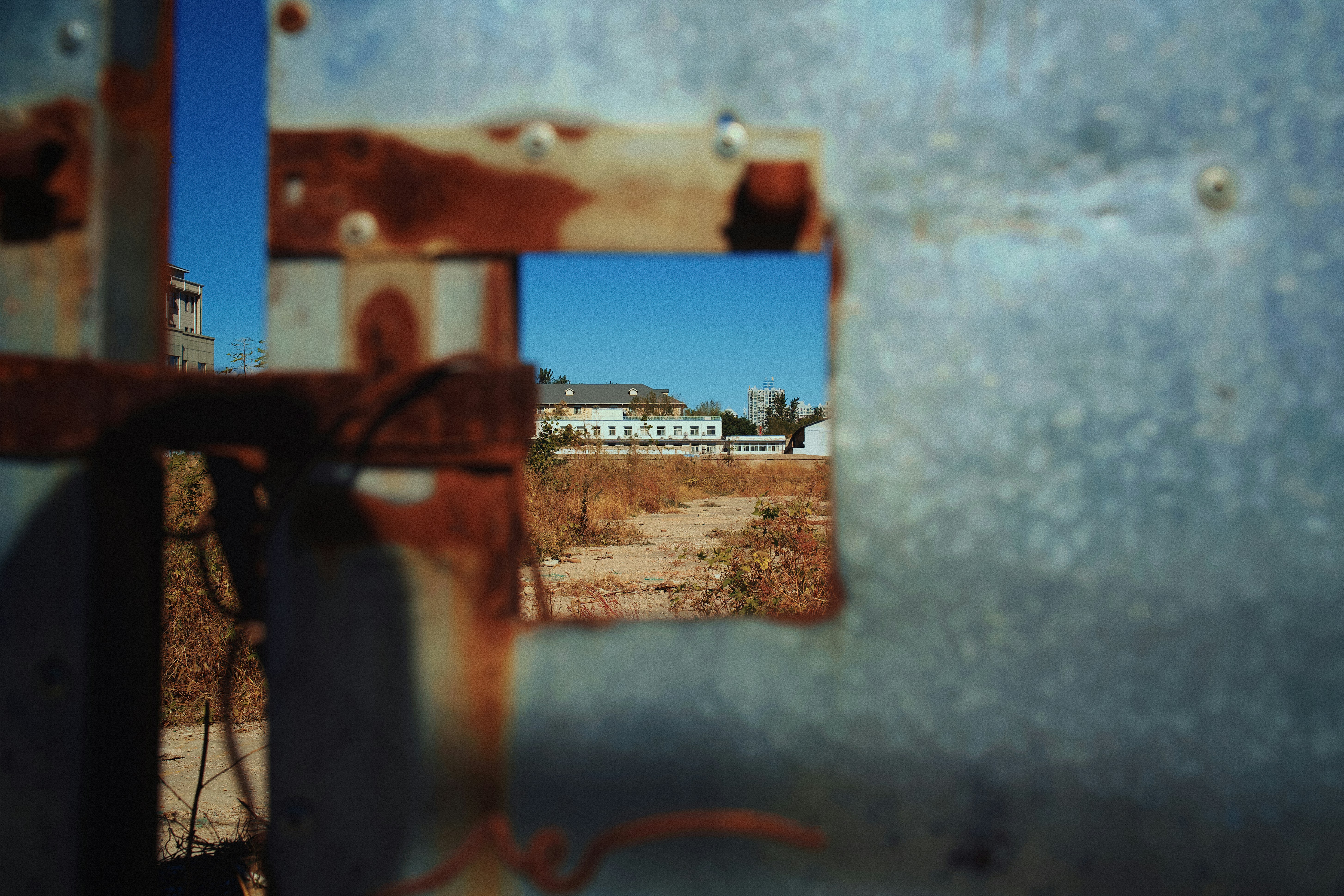 Framed Distant Houses Through a Weathered Window