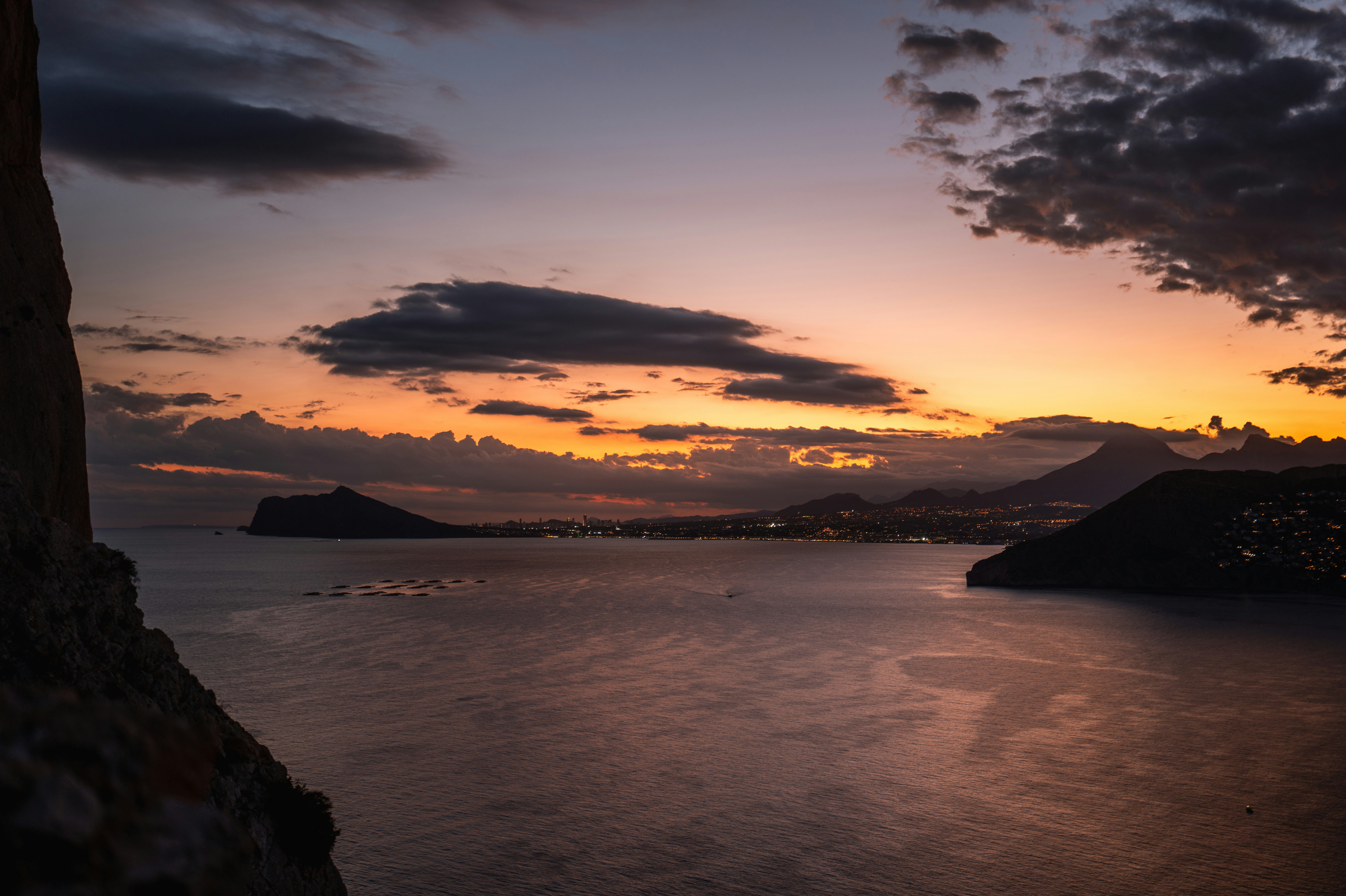 Sunset Overcalmed Cove: A Quiet Horizon Between Cliffside Darkness and City Lights