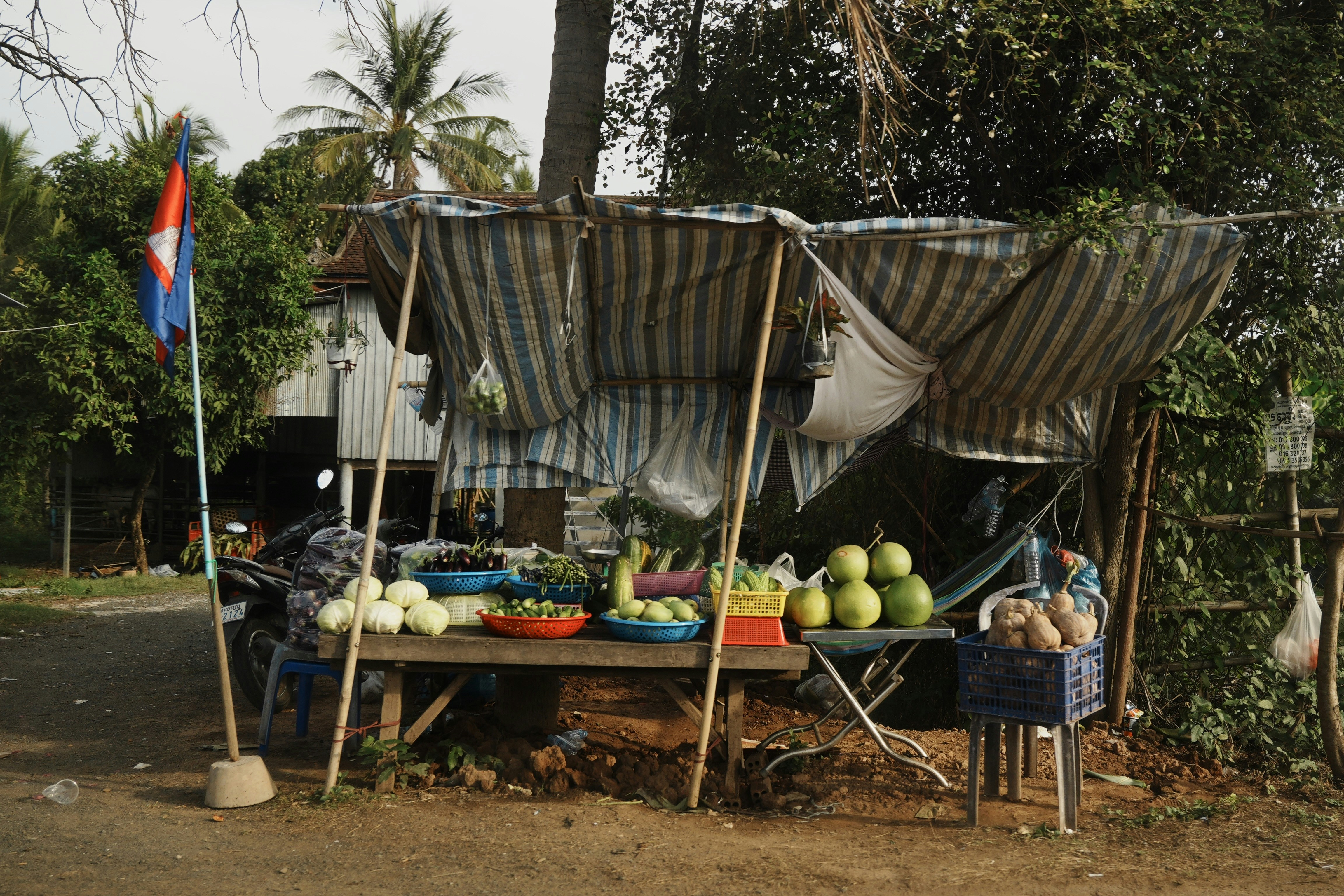 Straw-Canopy Market: Local Fruit Stand in a Tropical Lane