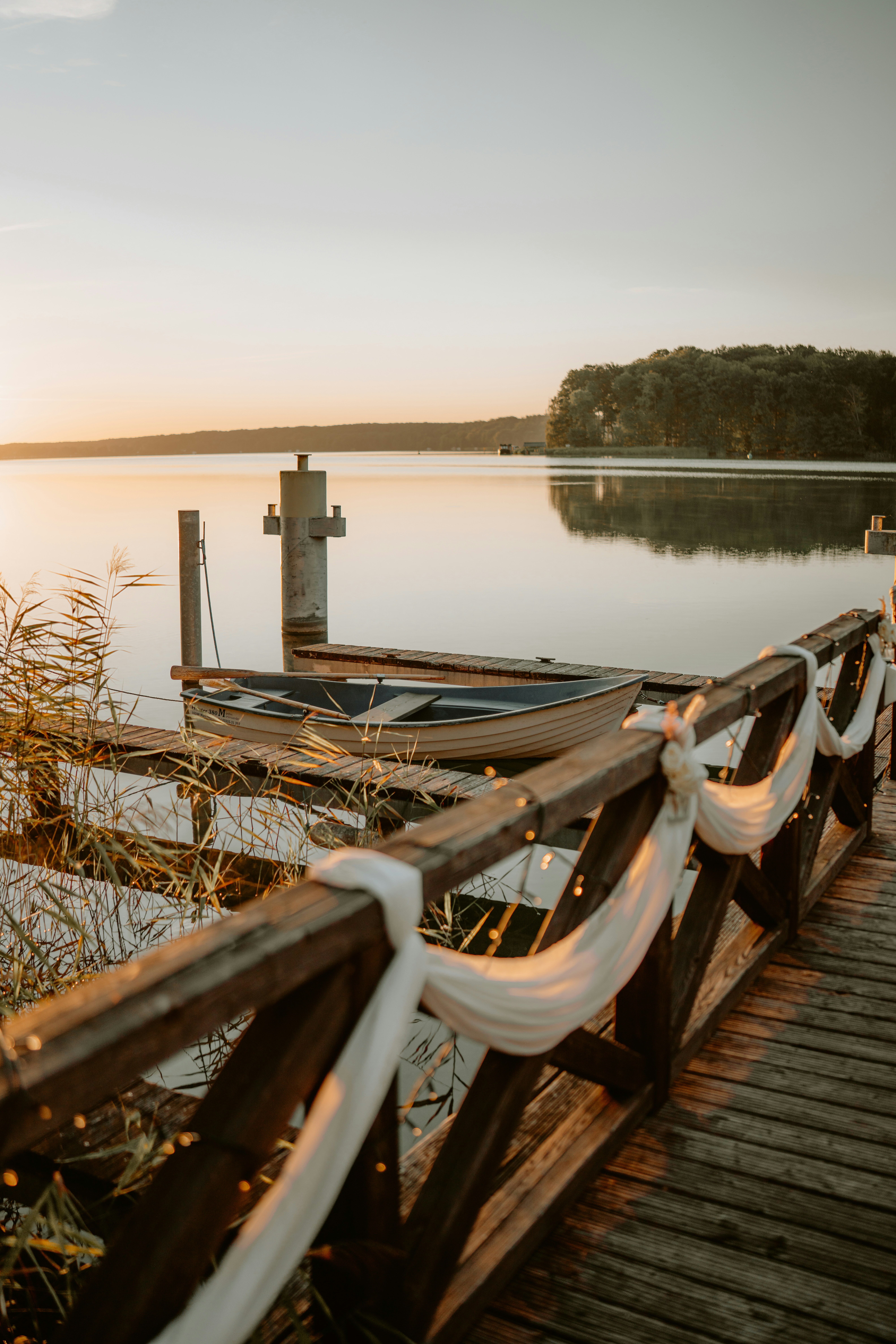 Golden Hour at the Wooden Pier: Boats Lounging by Frayed Drapery Ribbons