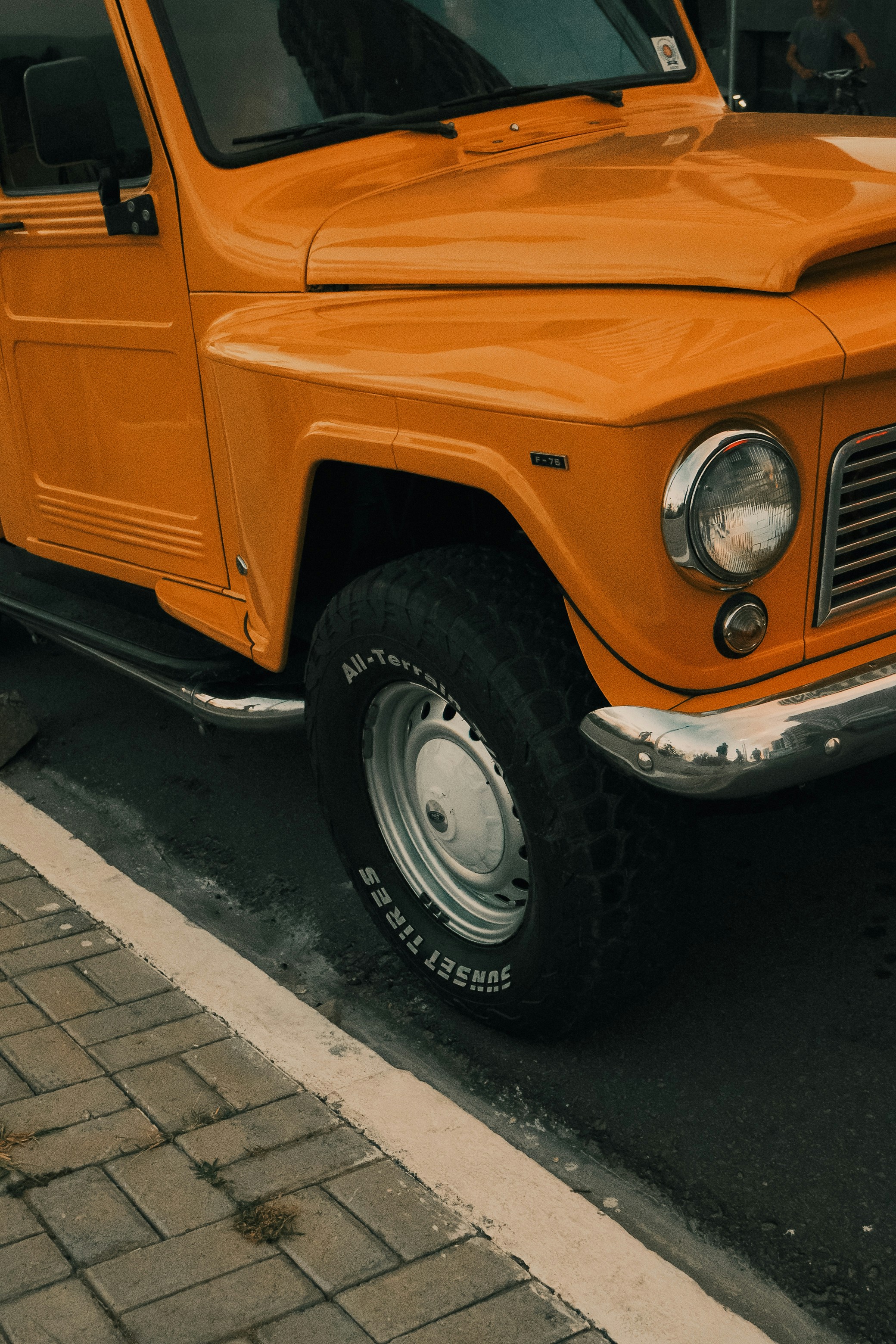 Sunlit Vintage Strength: The Front Quarter of a Bright Orange SUV