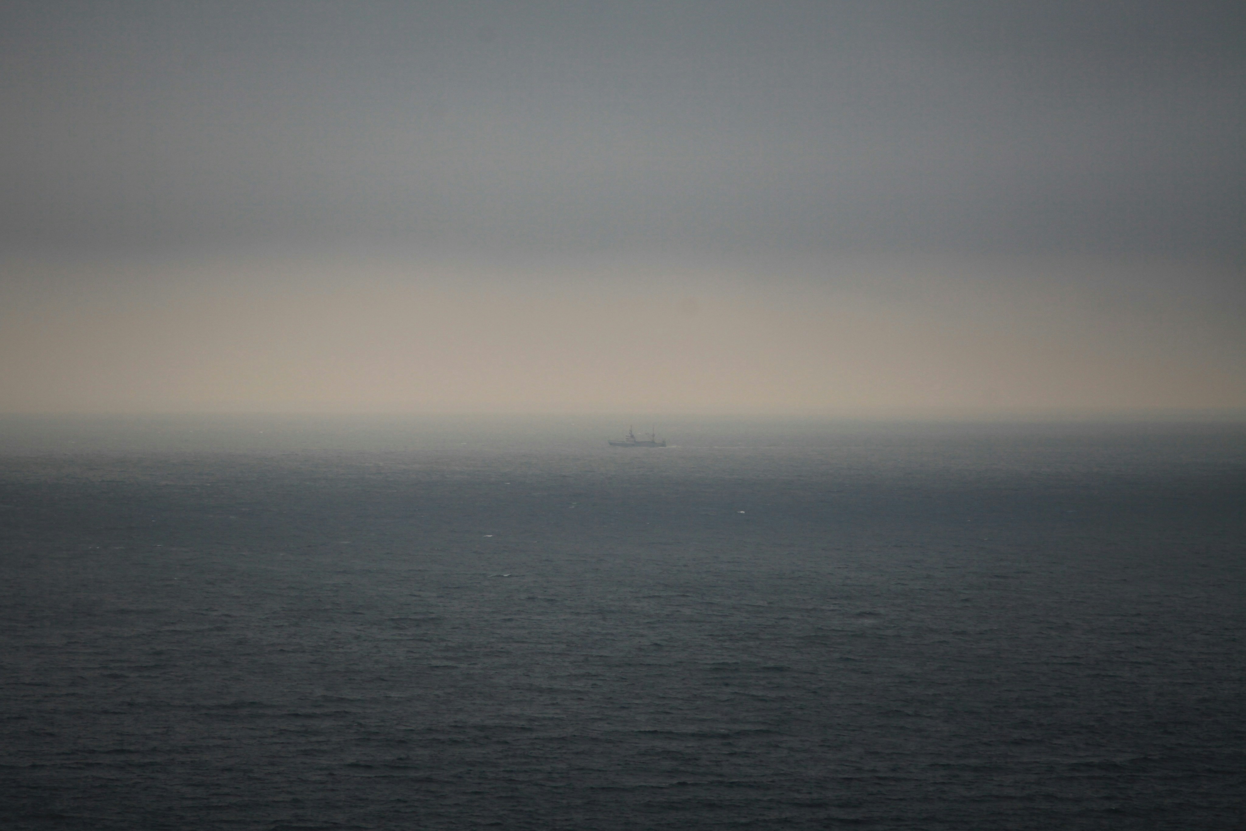A Distant Vessel Amid Quiet Sea Layers