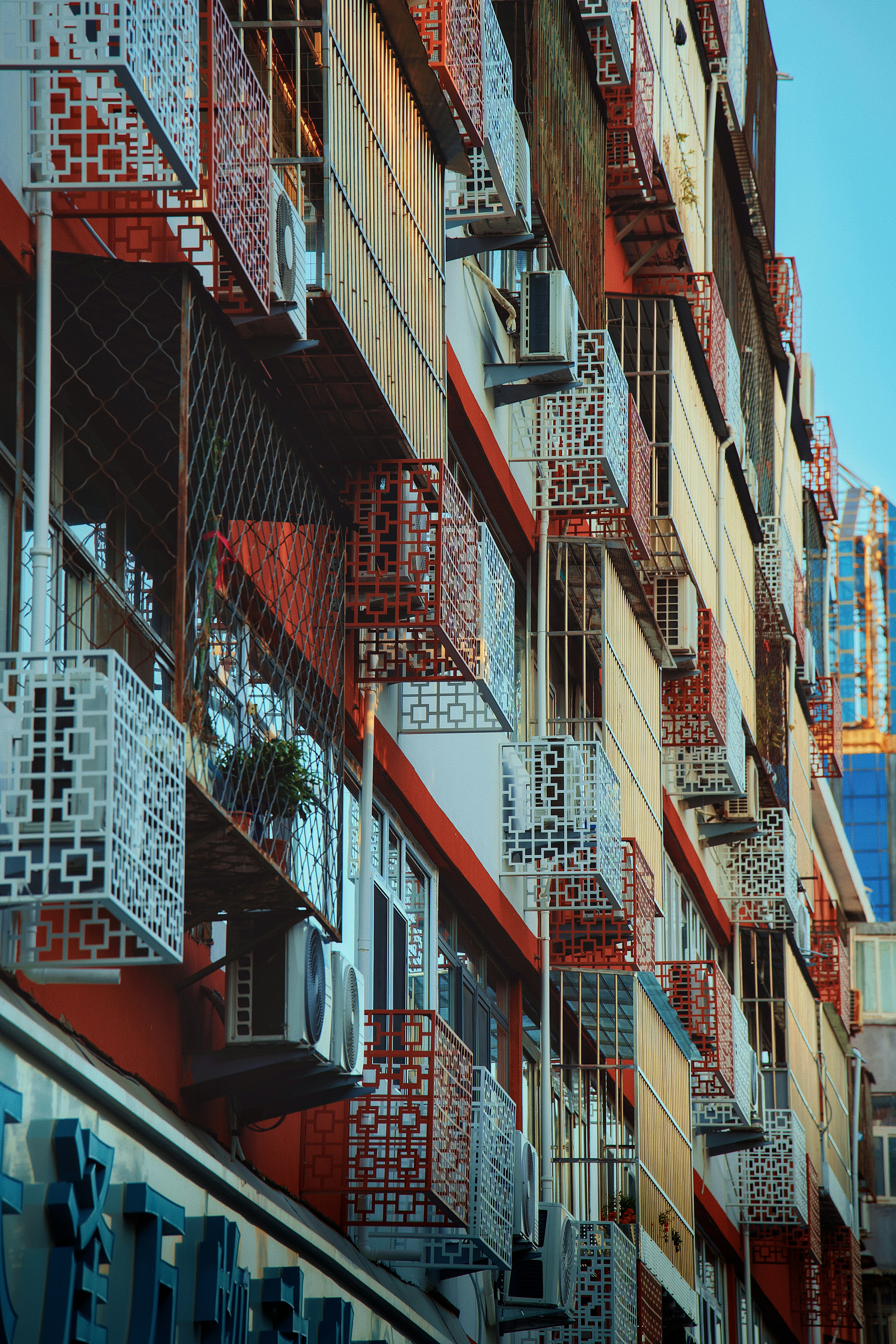 Balconies in Bloom: a grid of colored latticework faces a turquoise sky