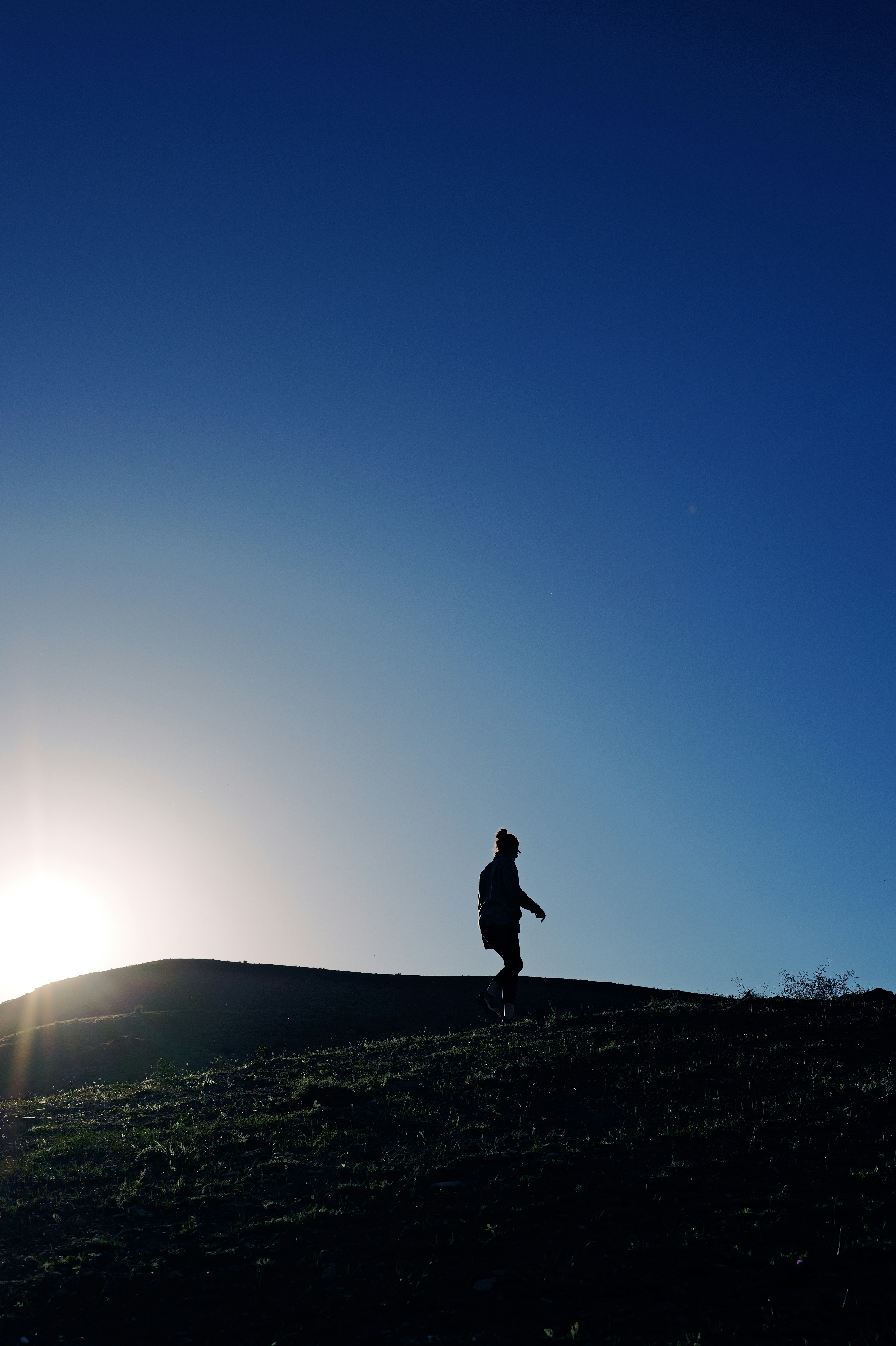 Dawn Silhouette: A lone wanderer on a sunlit hillside