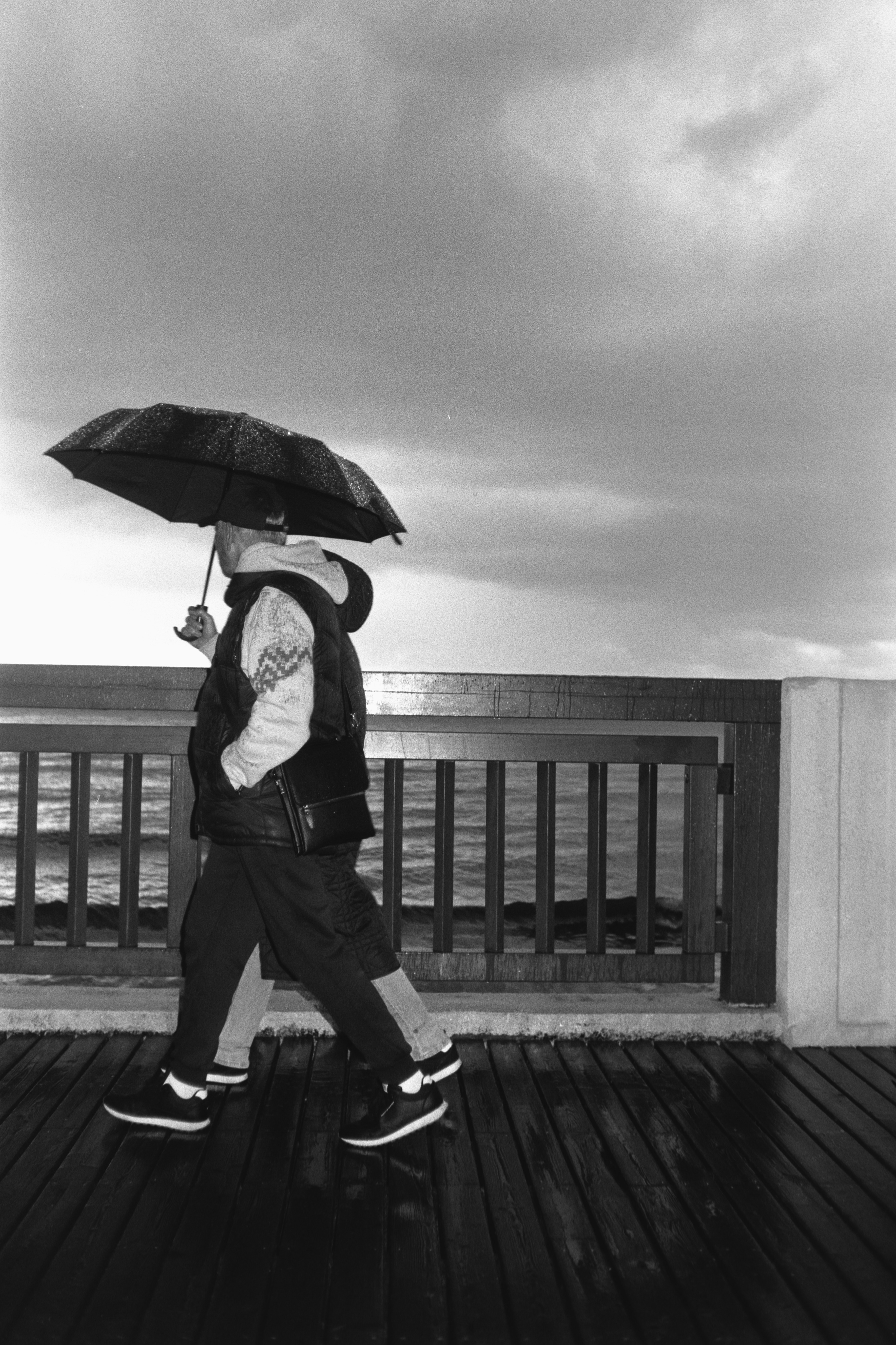 Umbrella Walk Along the Storm-Scored Boardwalk