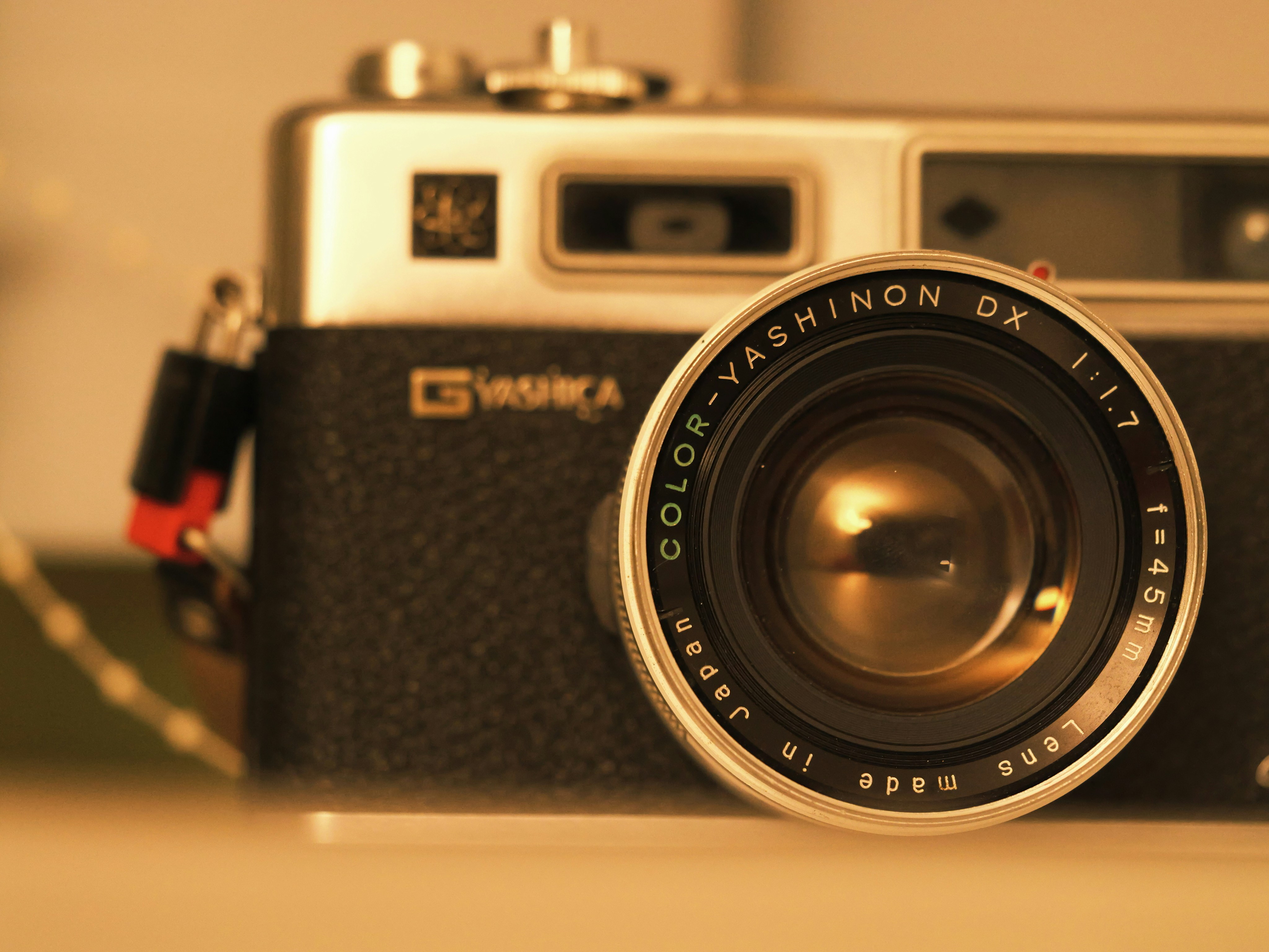 Vintage Focus: A classic Yashica rangefinder up close with its lens catching warm, amber light