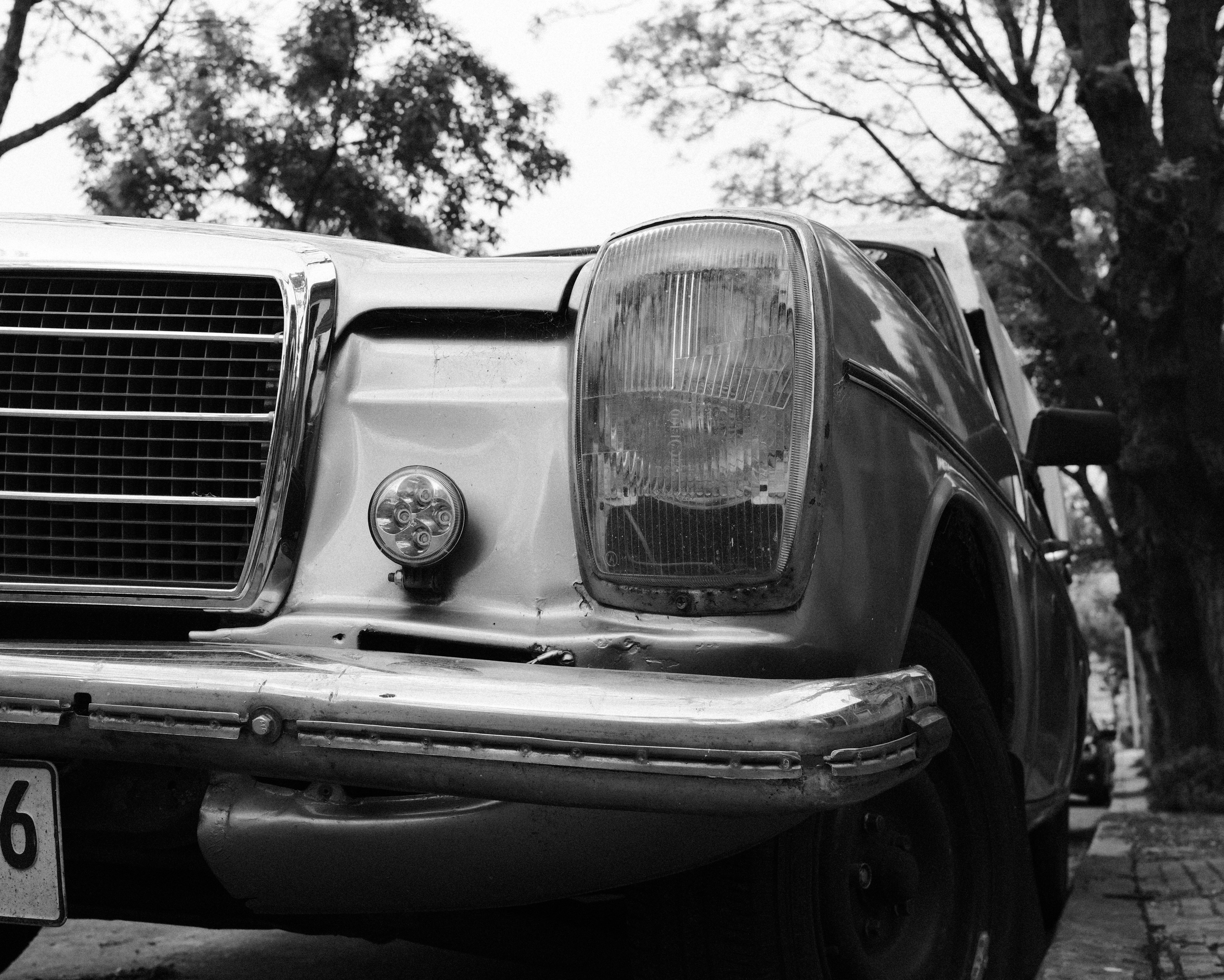 Weathered chrome and chrome-grilled gaze: a vintage car front in black and white