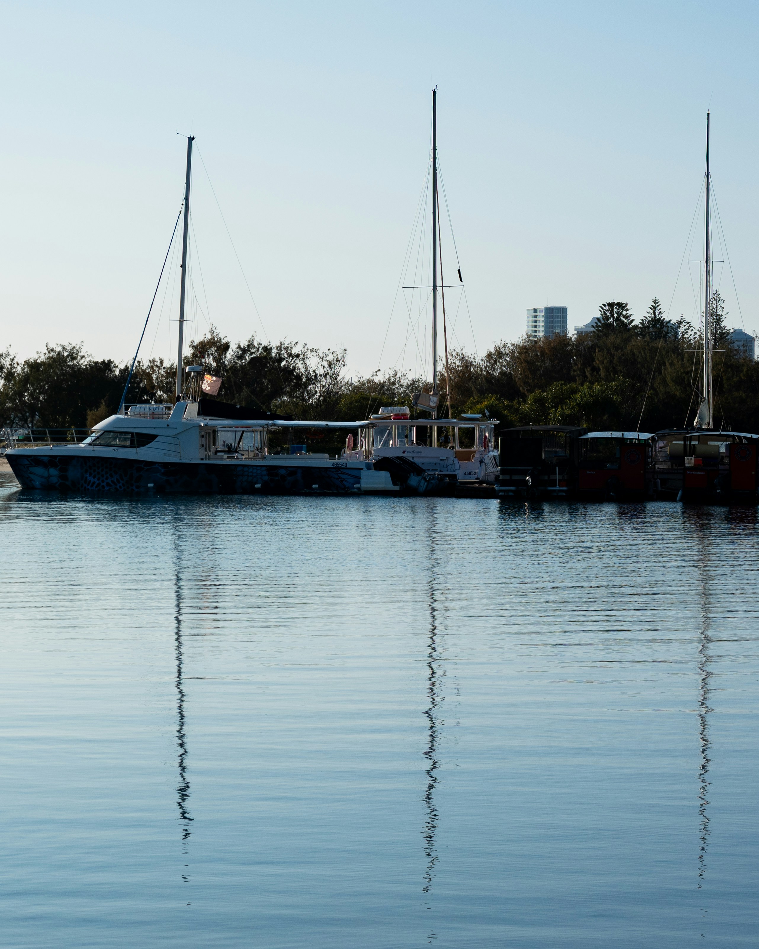 Harbor sailed in calm: boats and skyline mirrored on tranquil water