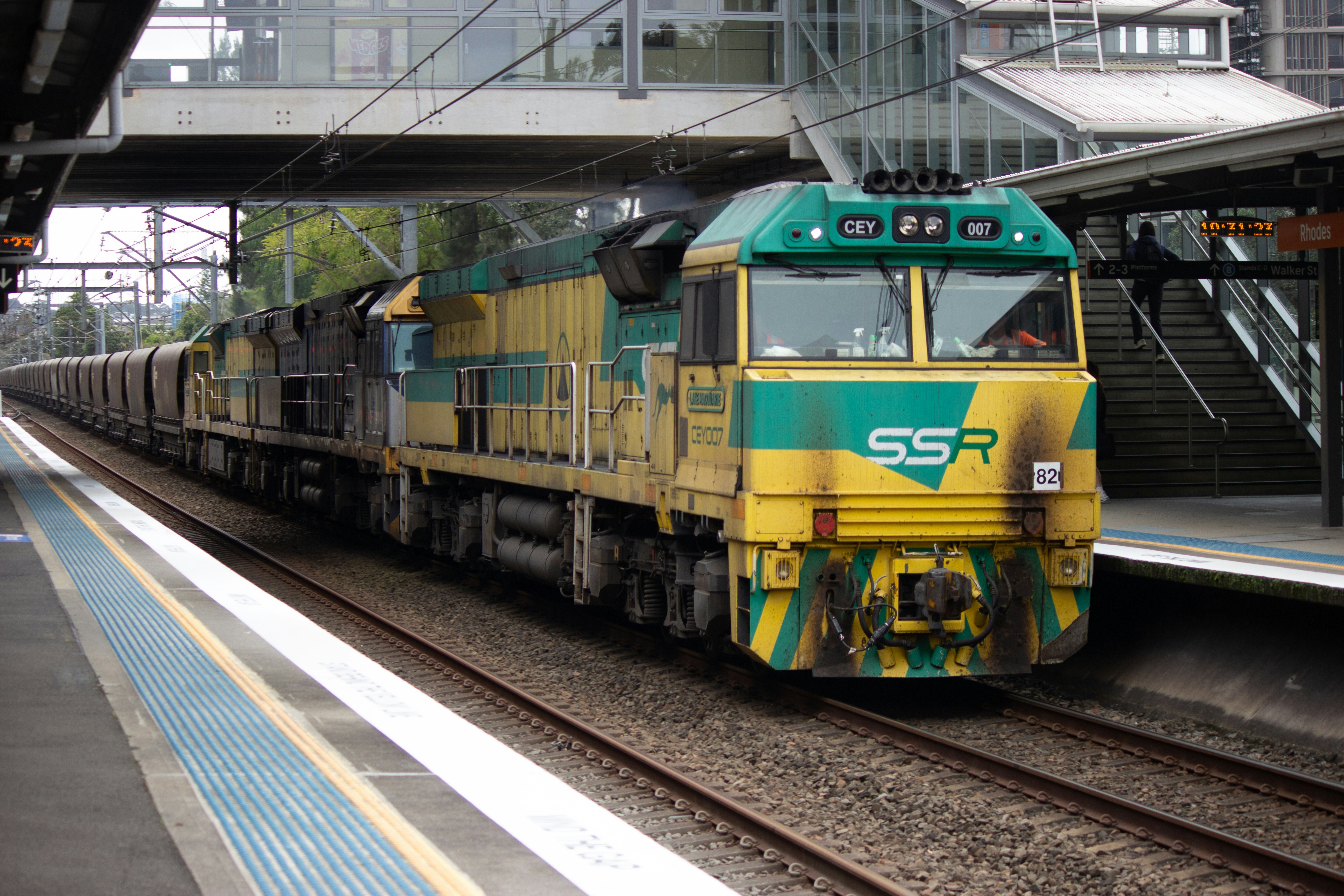 Electric Constancy: The Green-Gold Freight Engine at Platform Edge