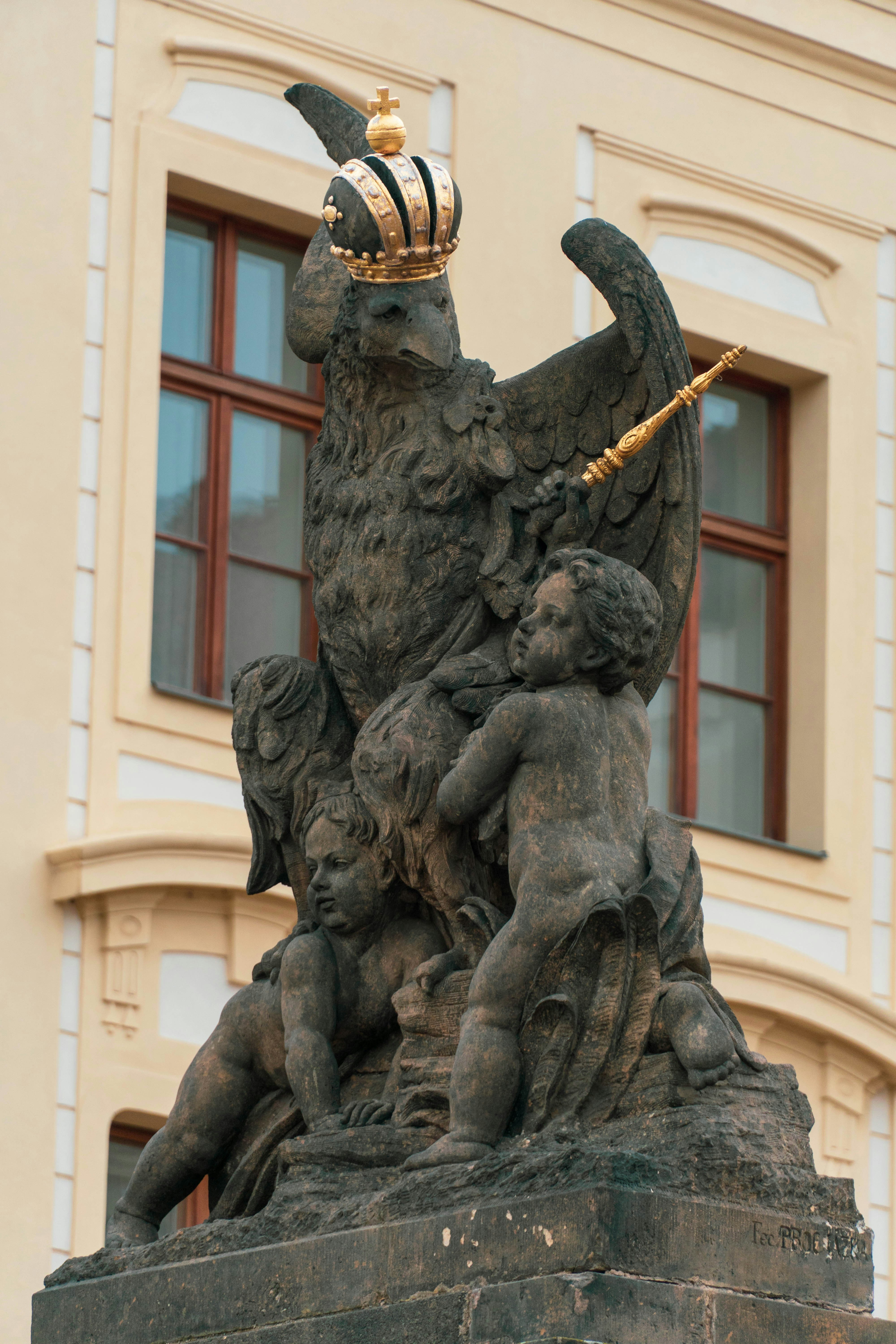 Crowned Eagle Overlooking Sacred Sculptures in Sunlit Facade