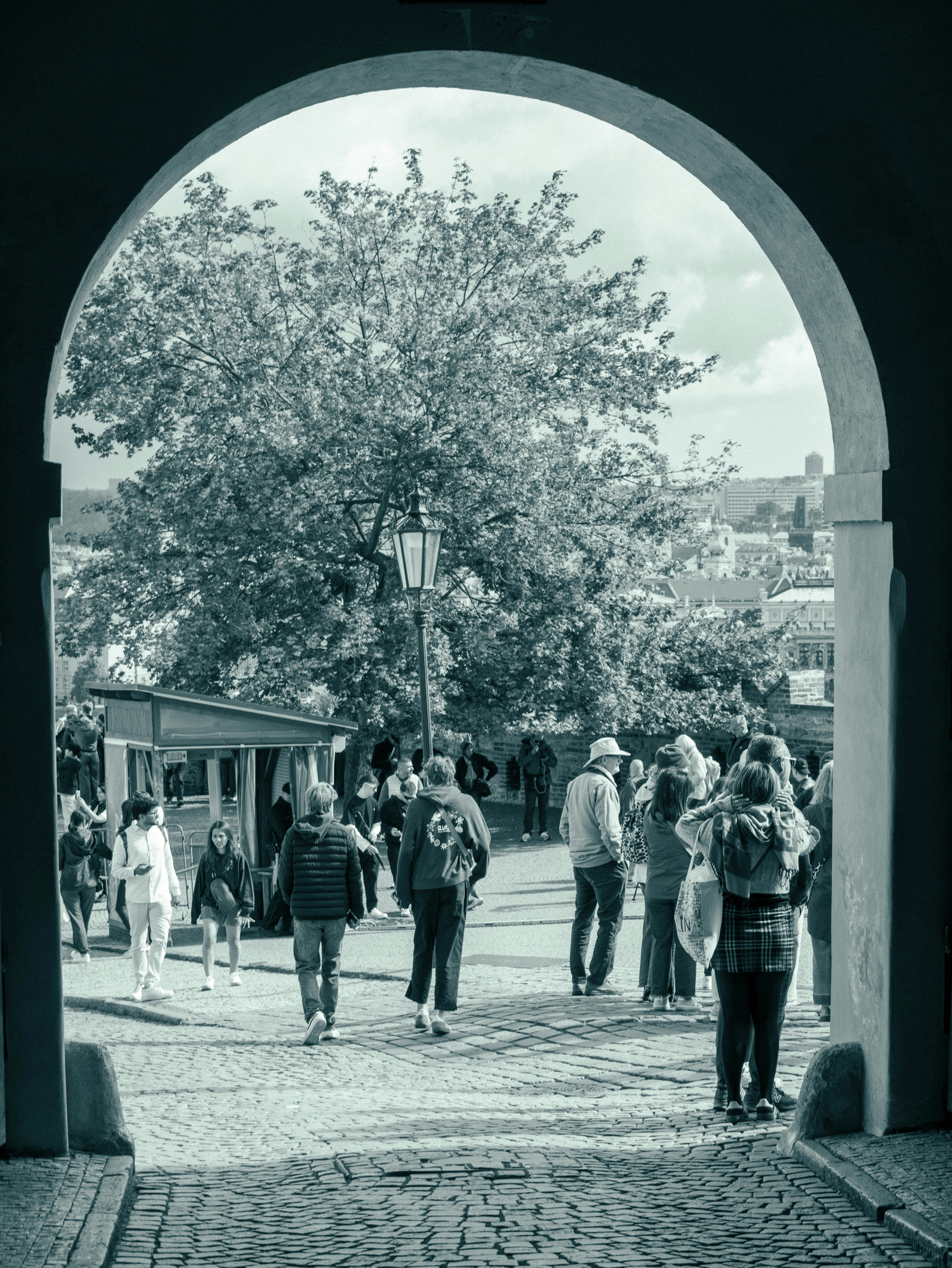 Through the Arch: People Gather Below a Shaded Portal