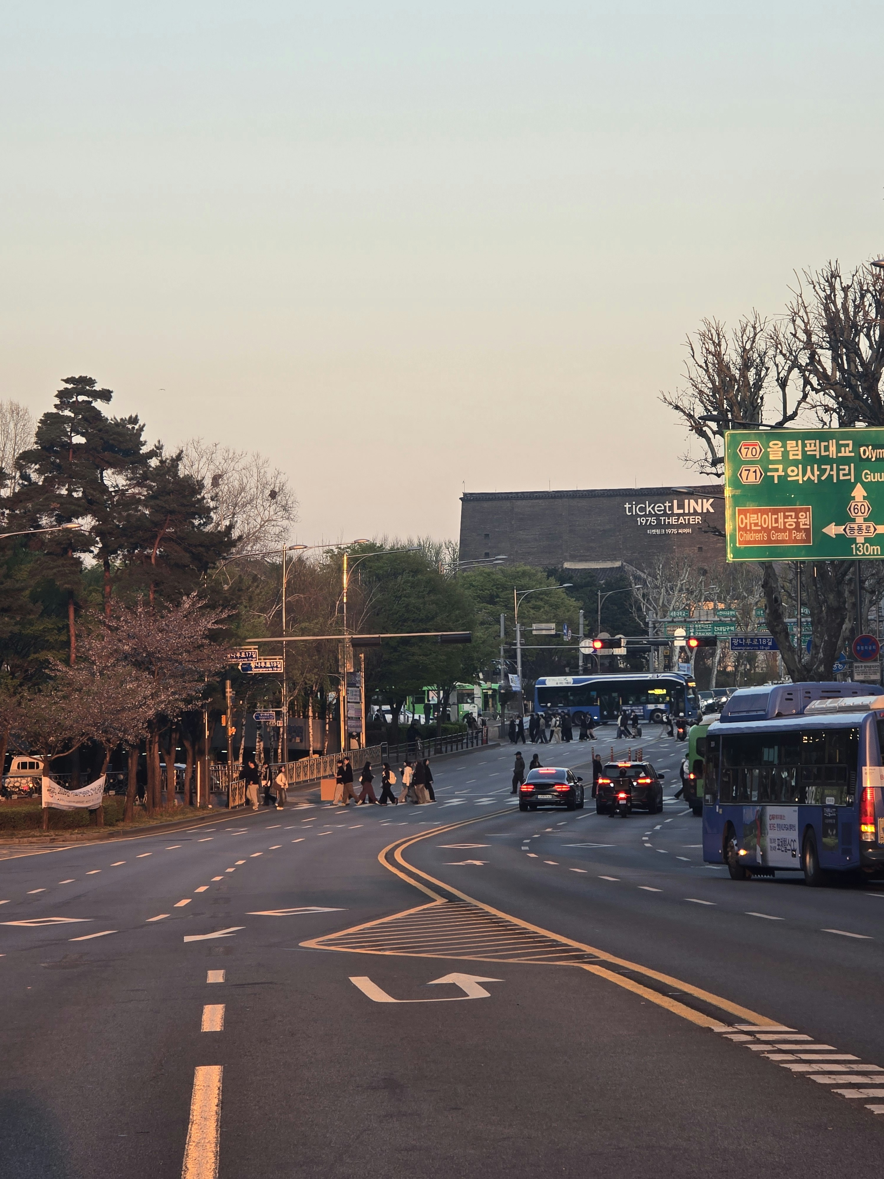 Evening rush: A sunlit boulevard funnels toward the theater