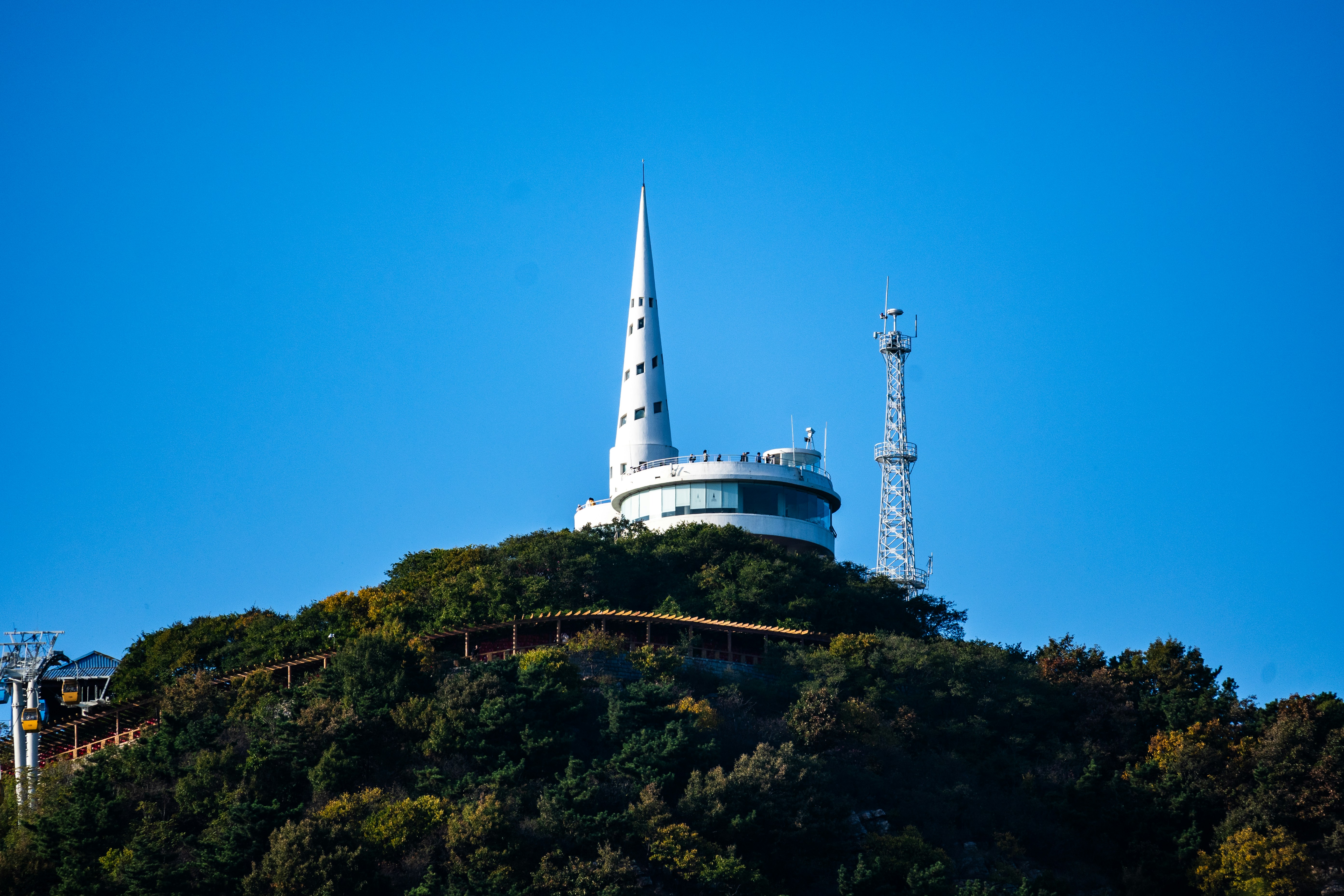 Spire atop the hill: a white landmark piercing the blue sky