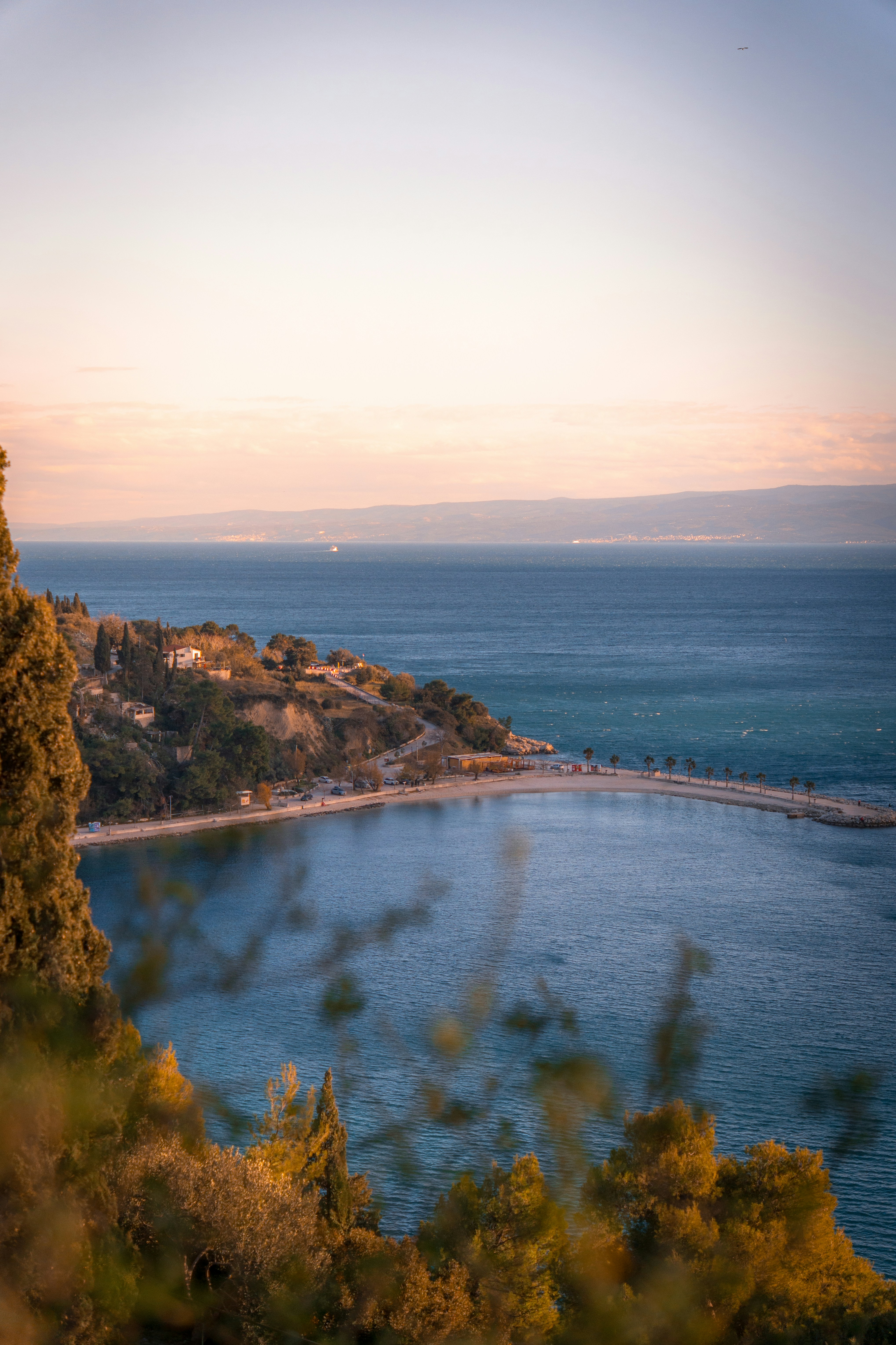 Sunlit Cove: A Quiet Peninsula Framed by Hills and Sea