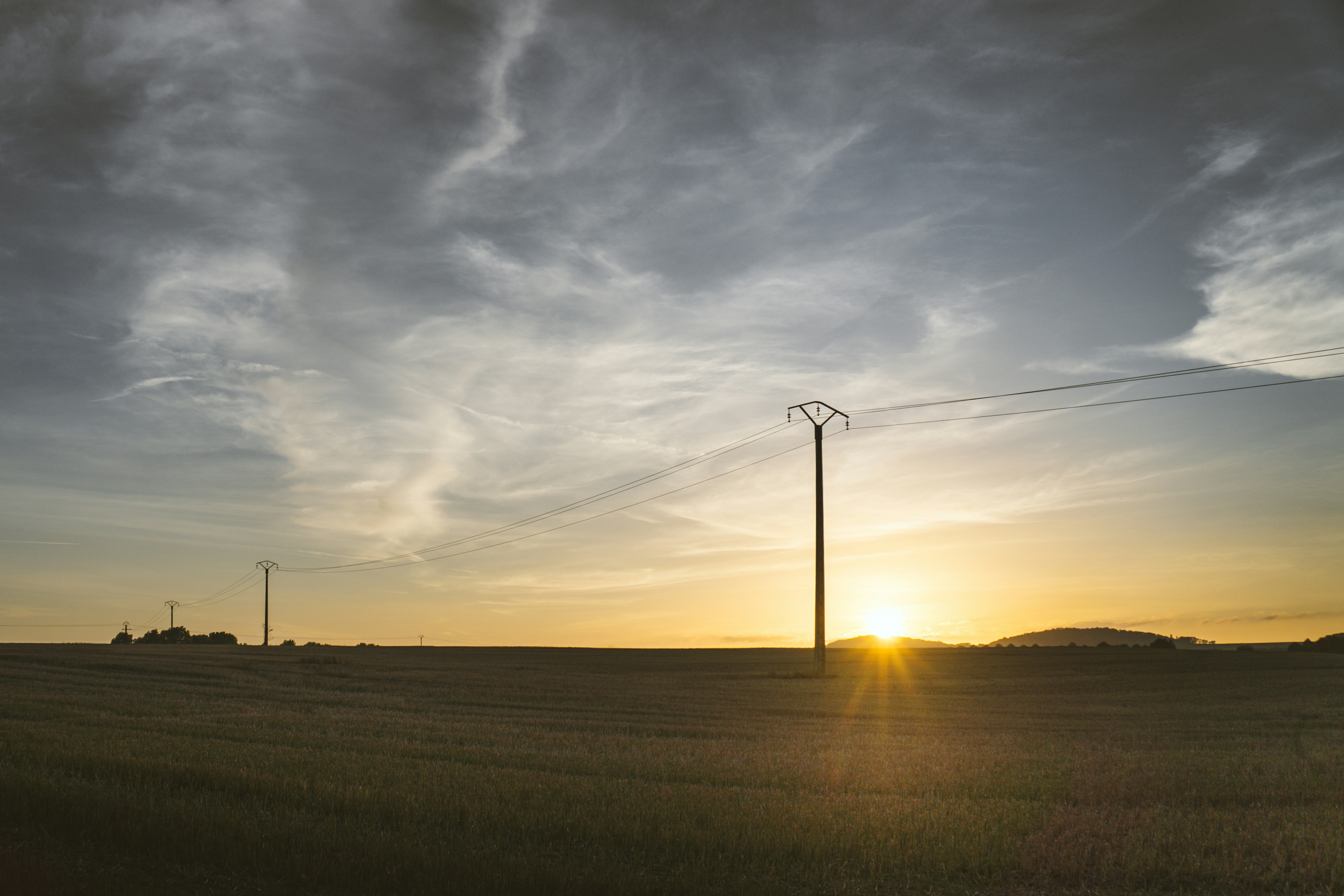 Sunrise at the Ridge: A Lone Power Line and Quiet Horizon