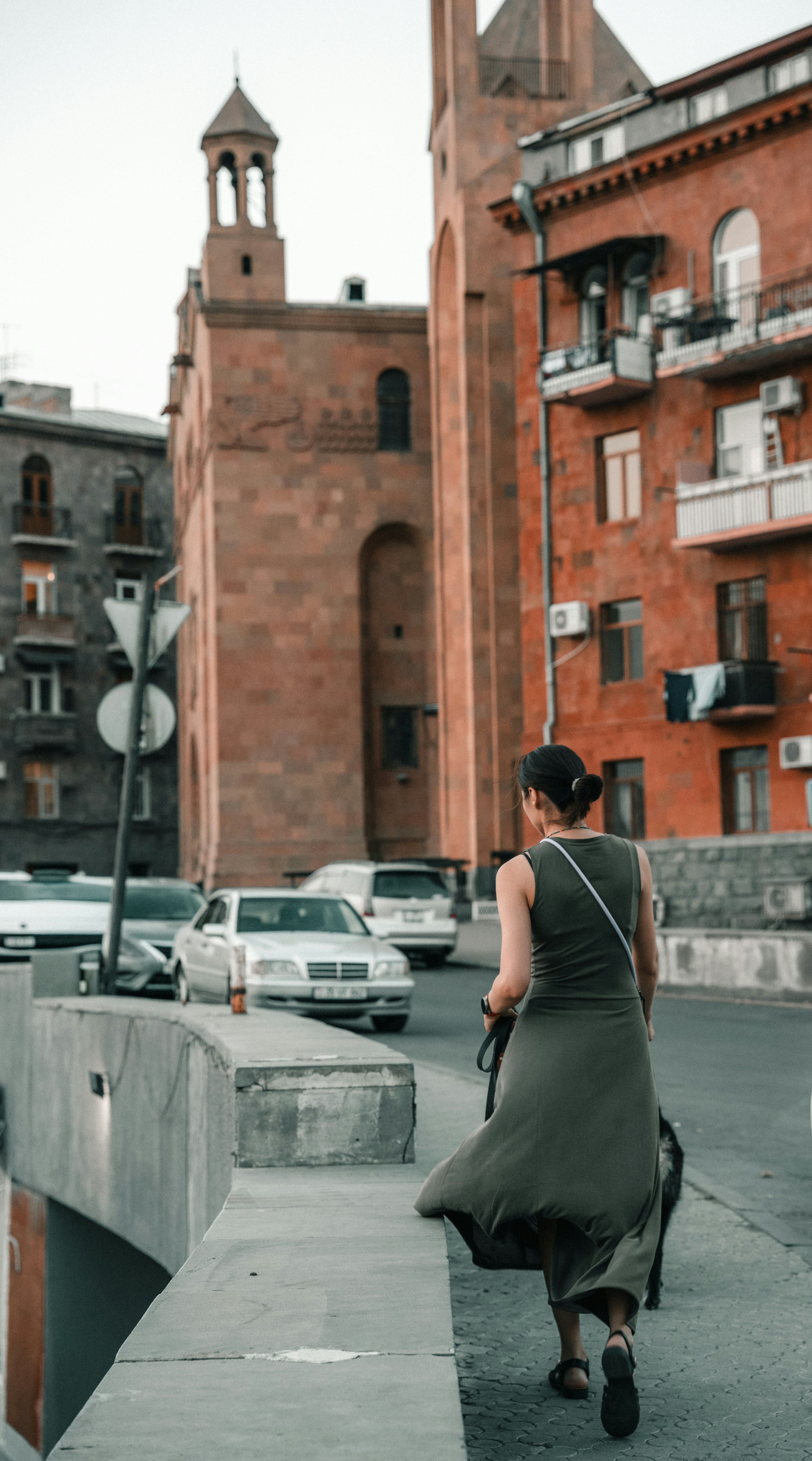 Walking the old city edge: a lone traveler on a brick street