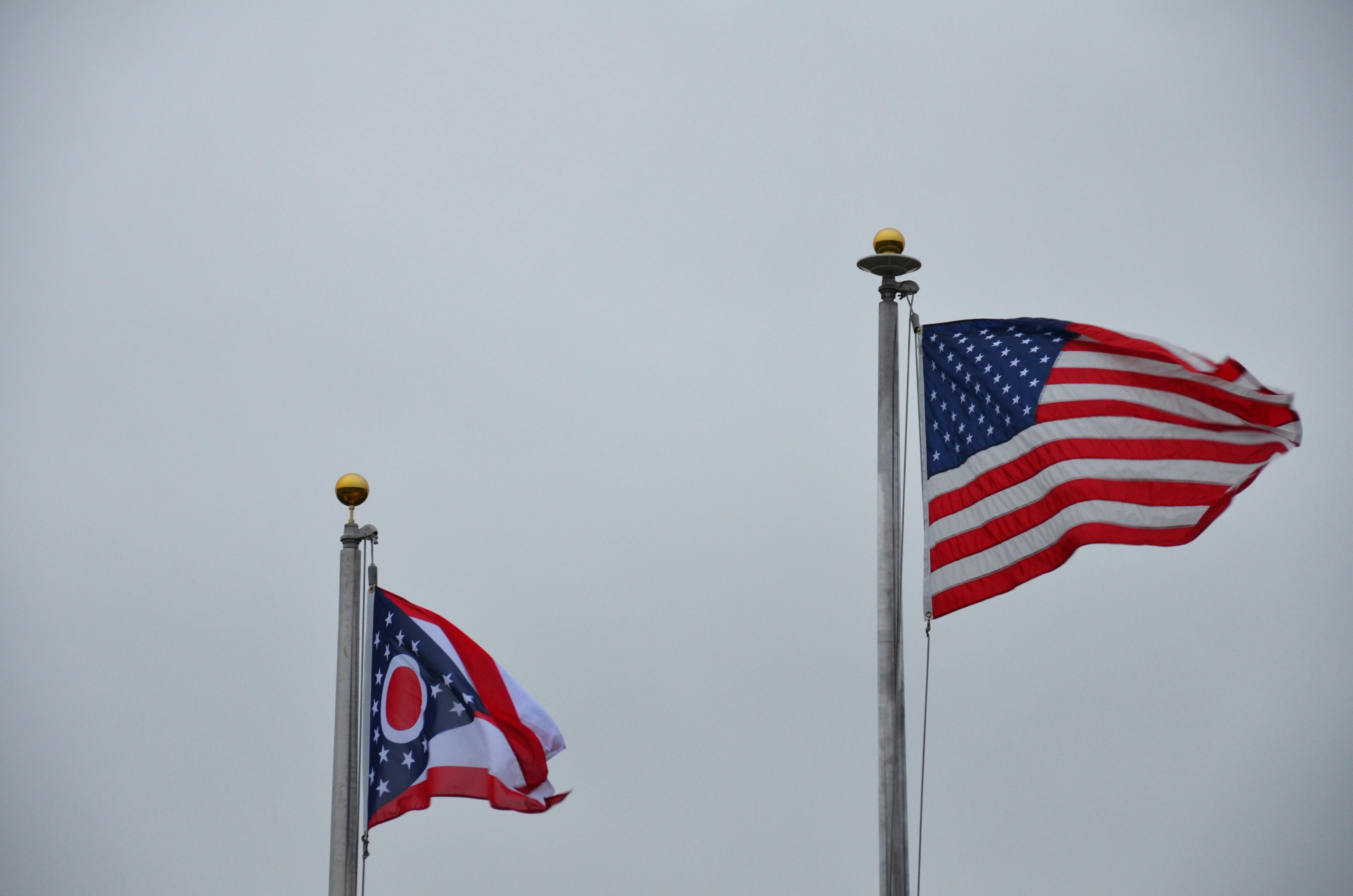 Two Flags, One Sky: Quiet Wind against a Pier of Liberty
