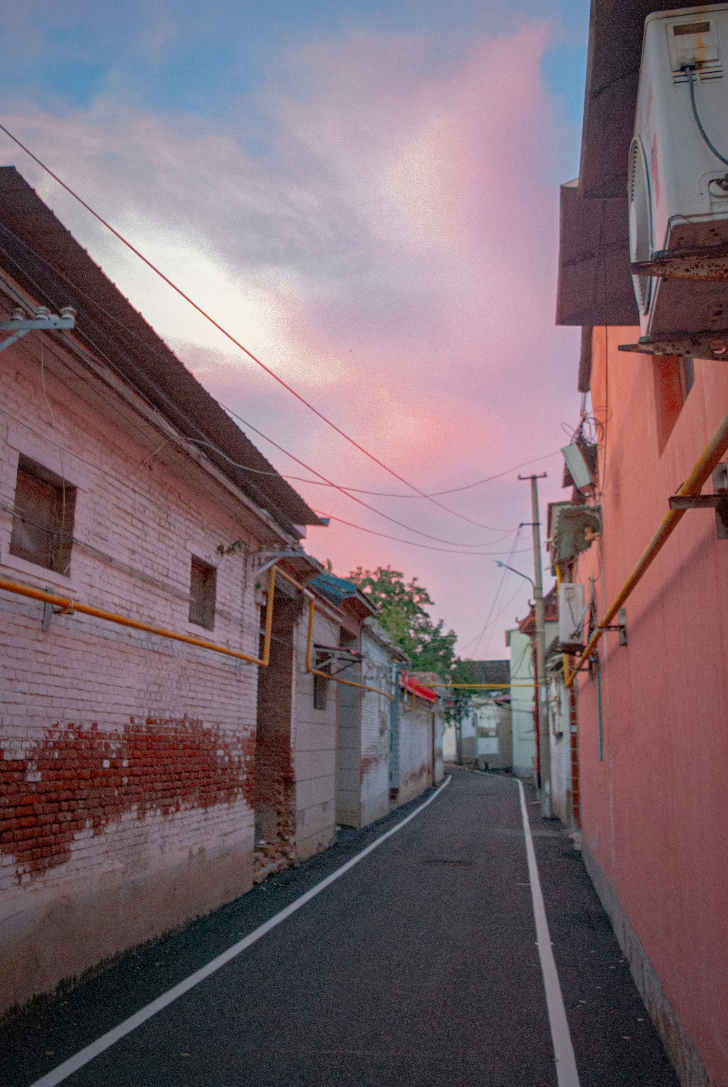 Sunset Alleyway: Pink Sky Above a Narrow Urban Corridor