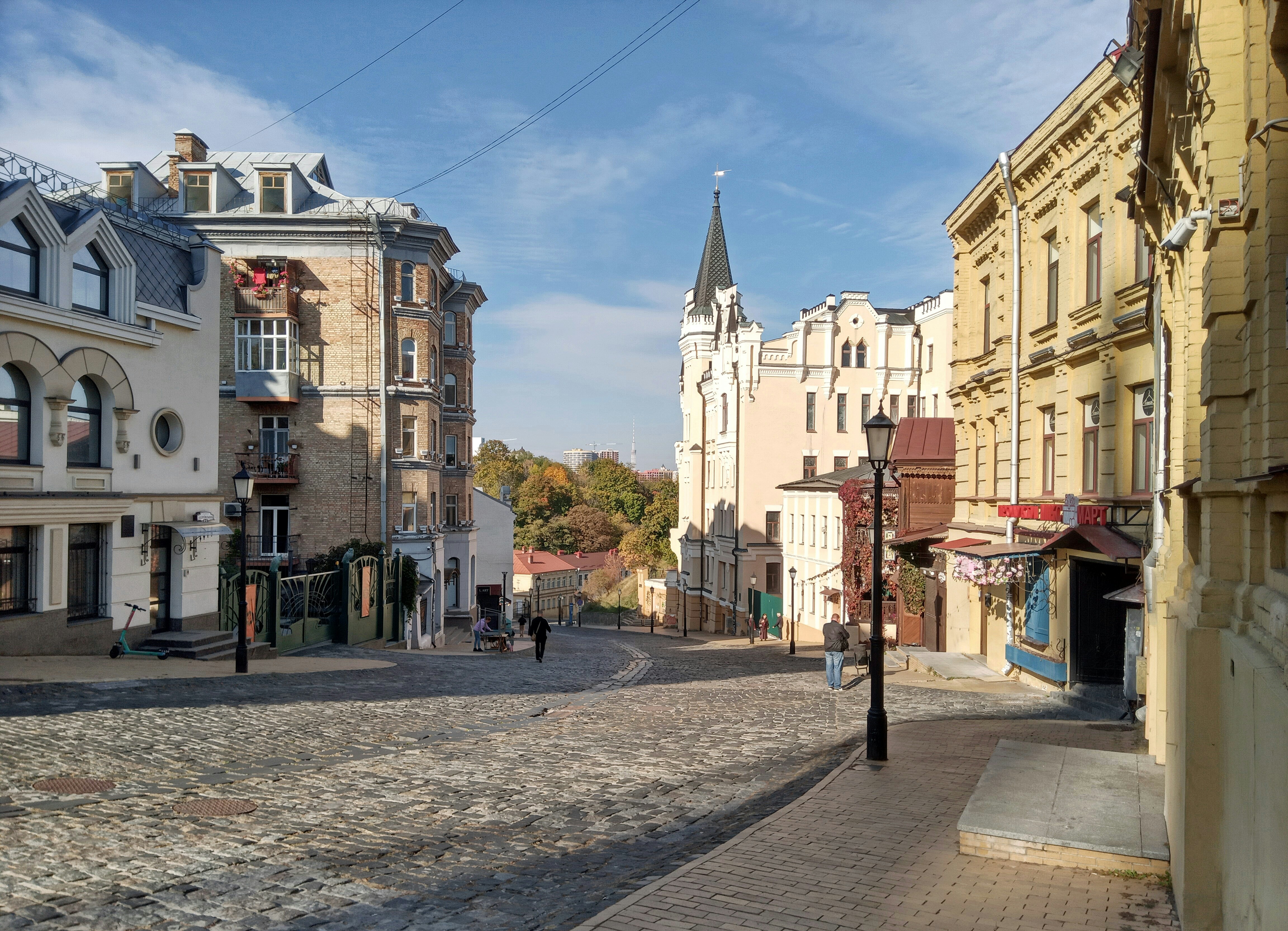 A Quiet European Street: Cobblestones Leading to a Towered Promise