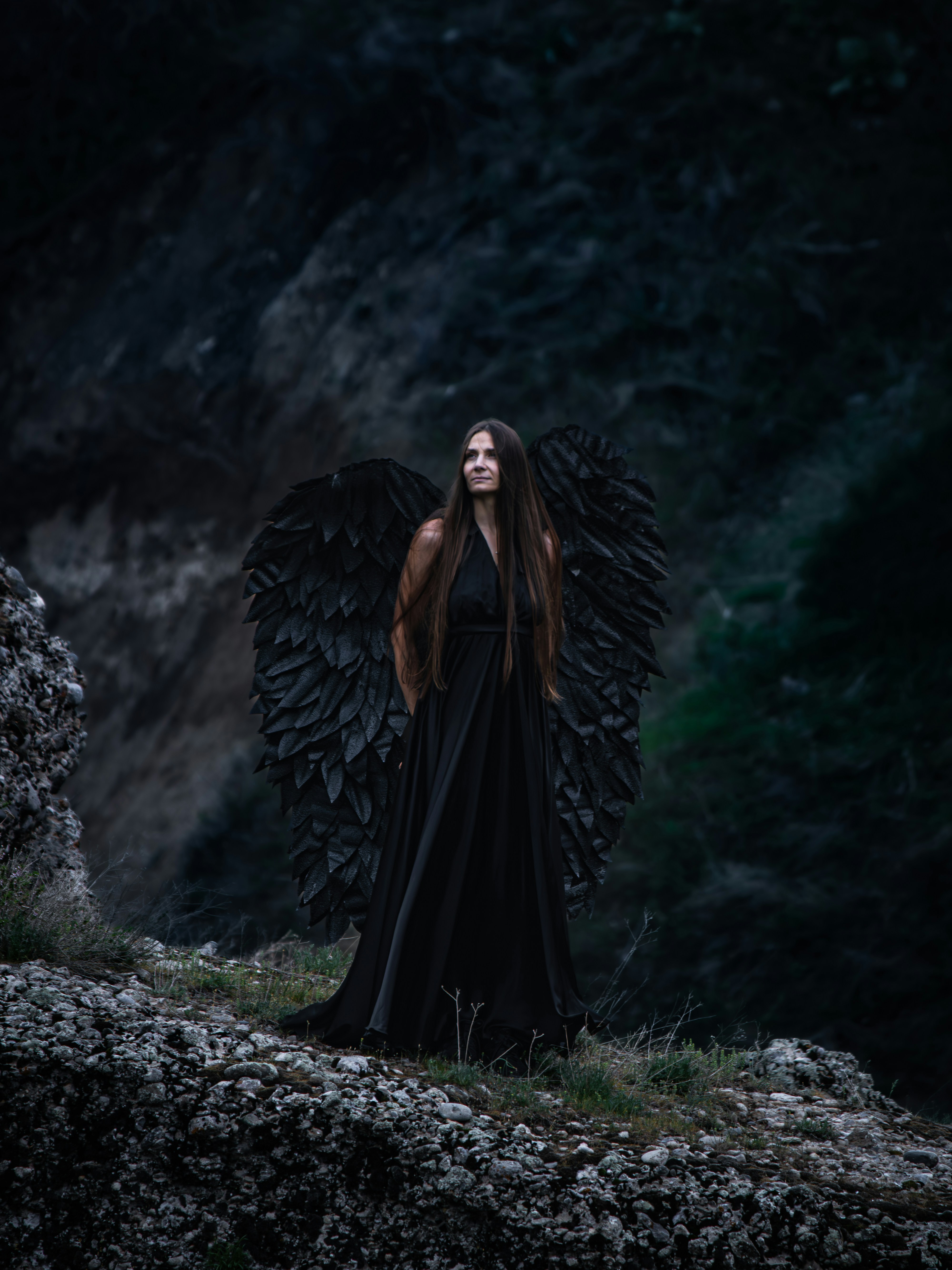 Wings of Nightfall: A Dark Angel Perched on Craggy Outcrop