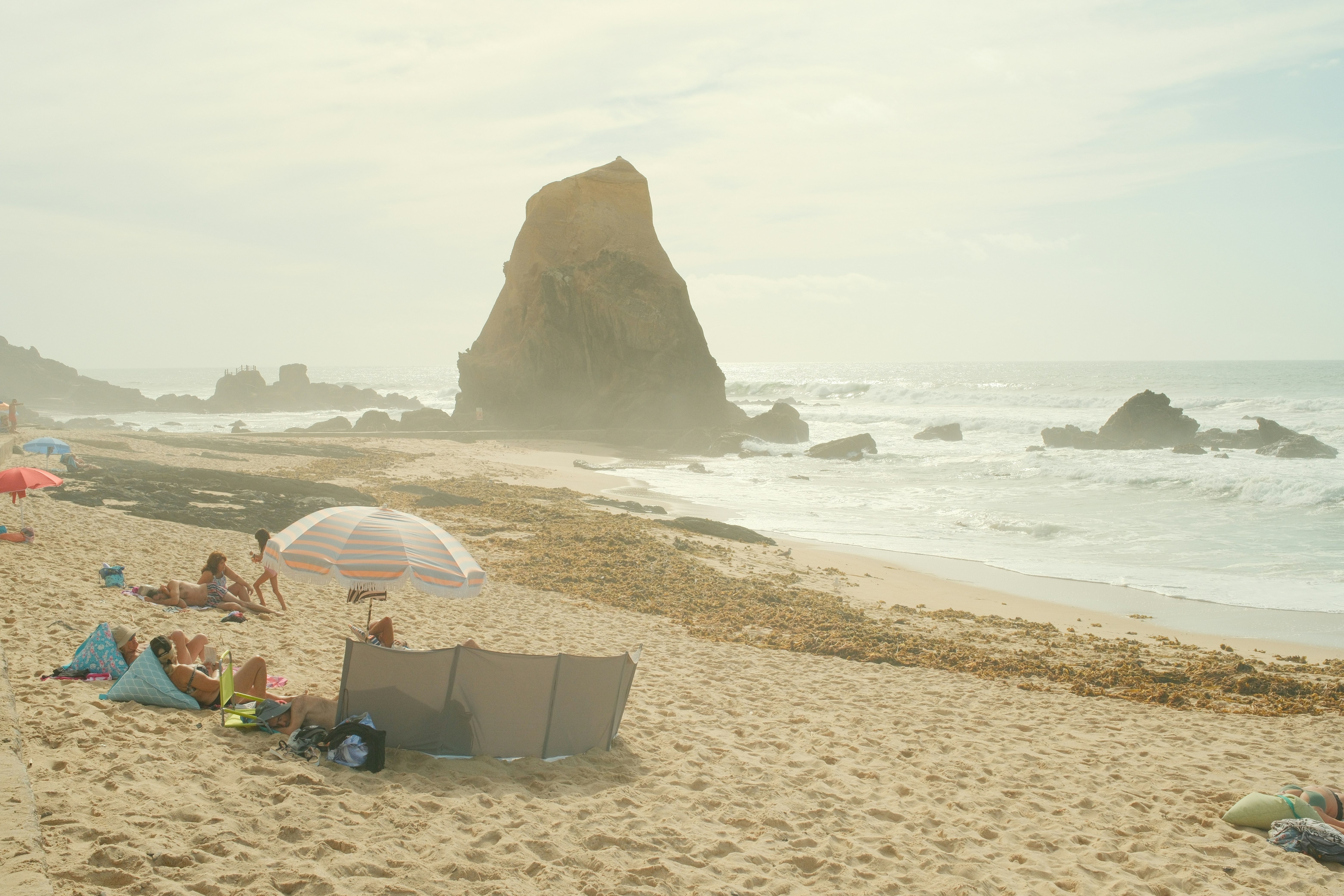 Sunlit Beach Break: Soft Focus, Quiet Dunes and a Sea-Rock Sentinel